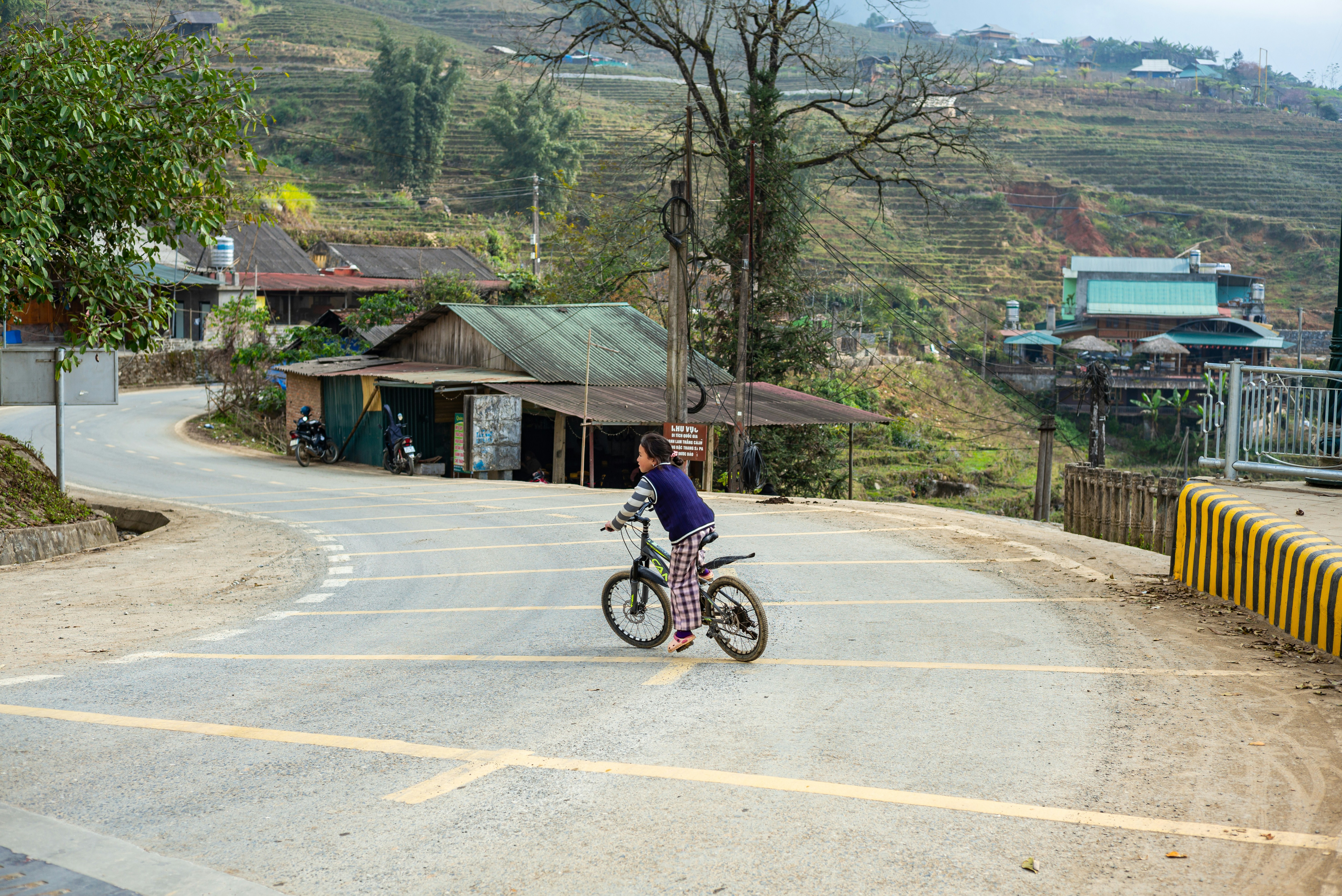 Child on a Bicycle at a Quiet Hill Village Curve