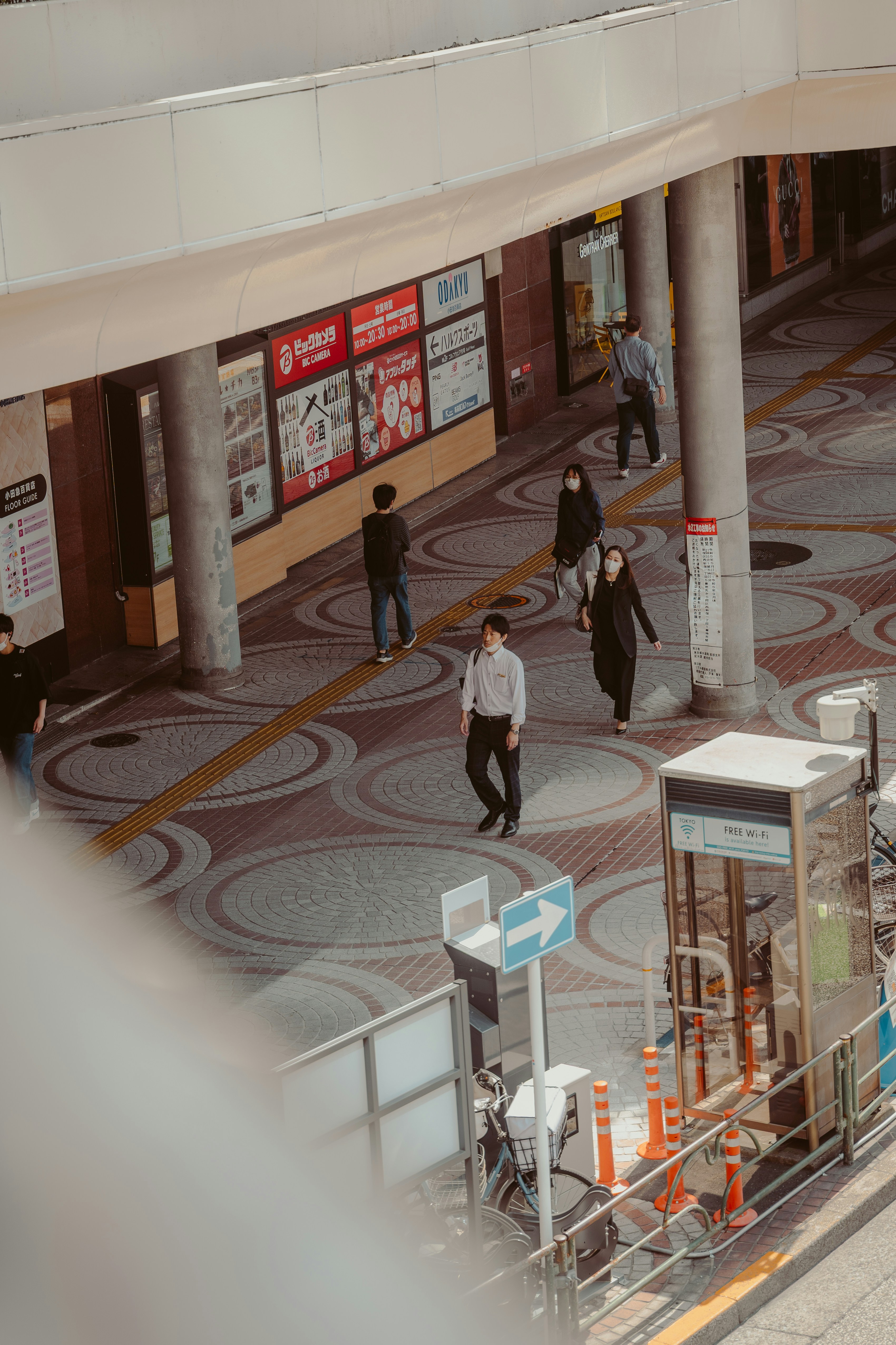 Urban Passage: commuters cross a sunlit arcade beneath tiled curves