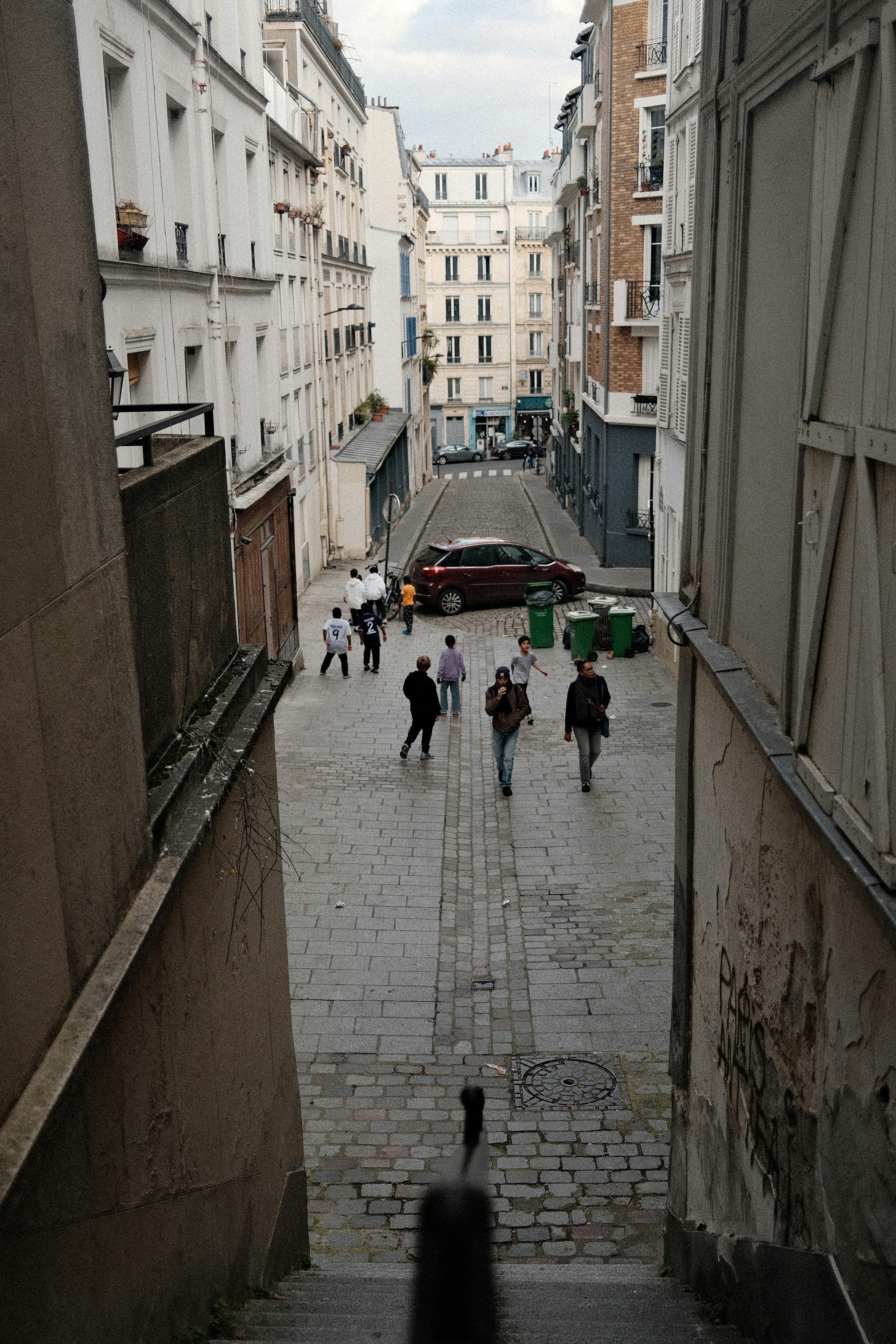Upward Street: People Climb a Quiet Parisian Alley