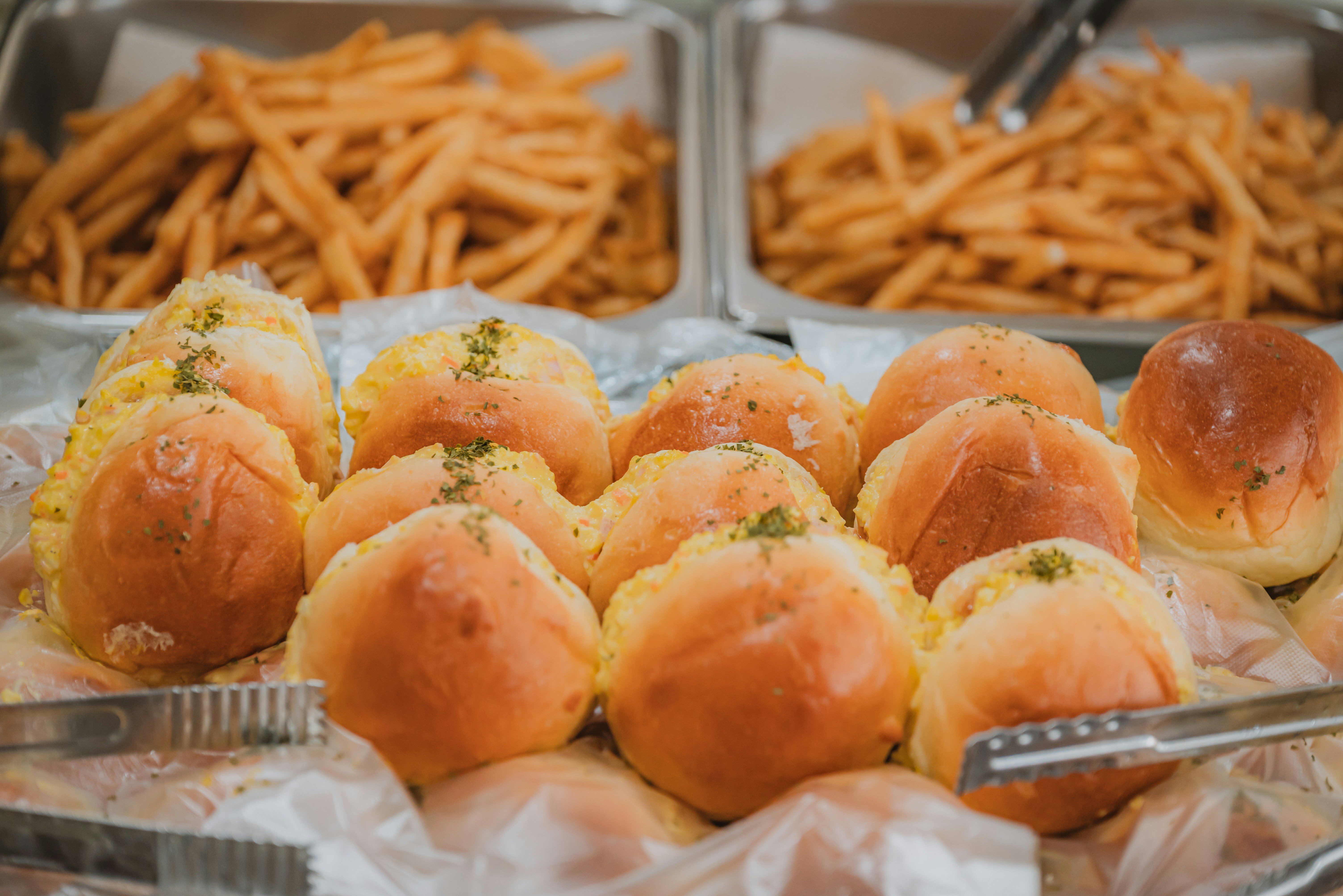 Tray of golden-brown buns under warm lighting with crispy edges