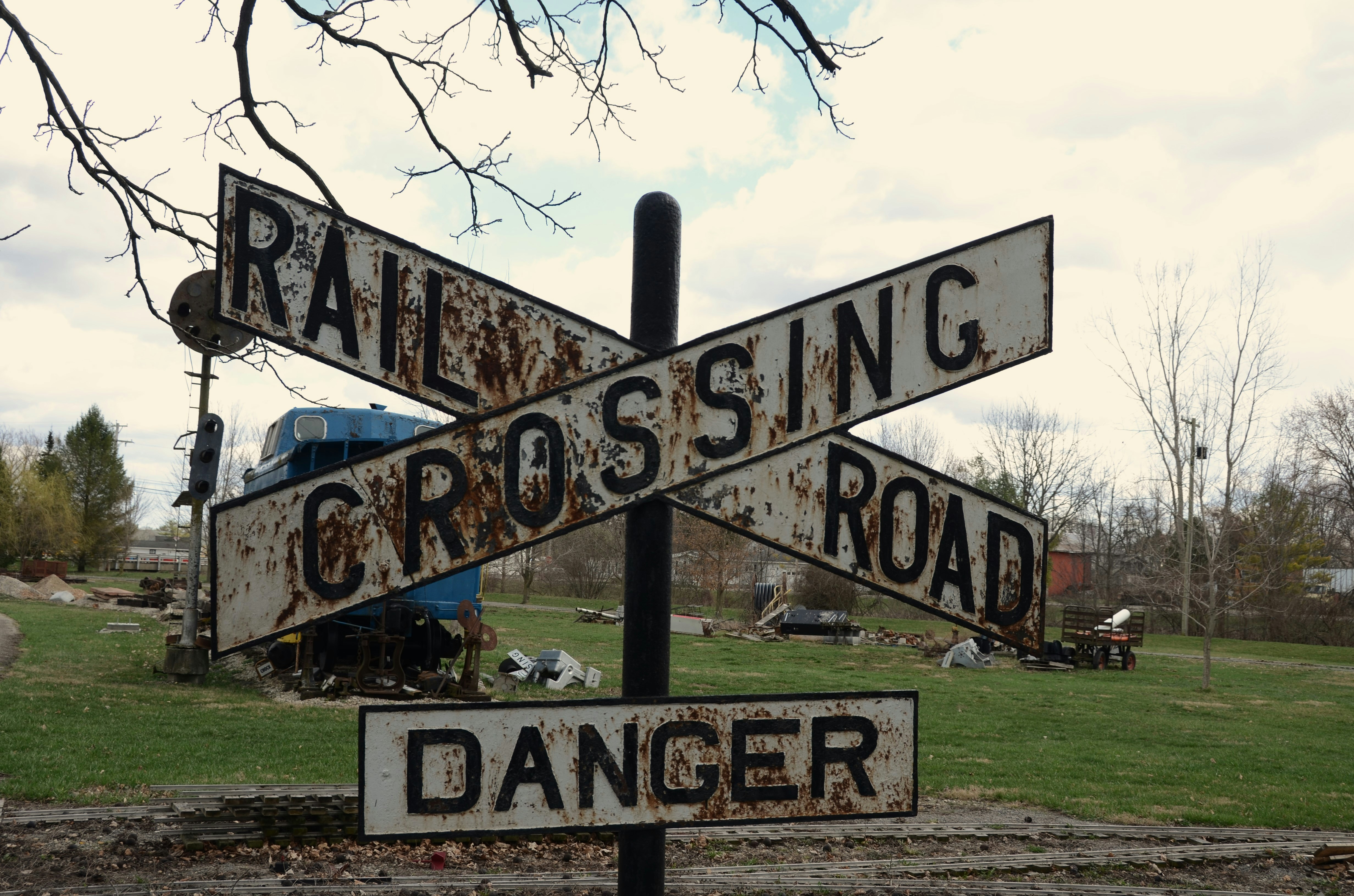 Rusty Crossings: Weathered Signpost at Abandoned Rail Yard