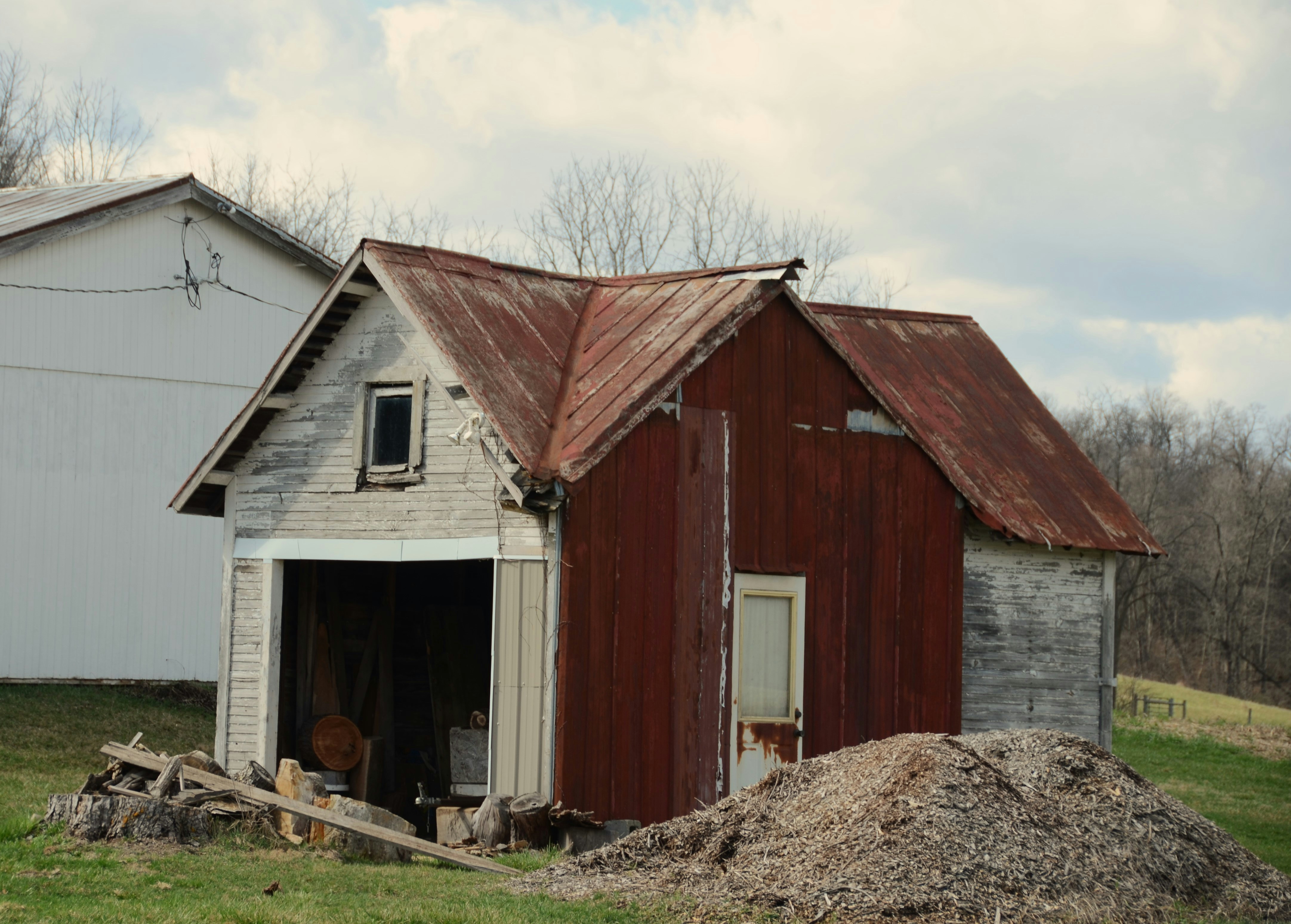 Weathered Farm Shed with Rusted Roof and Piled Gravel