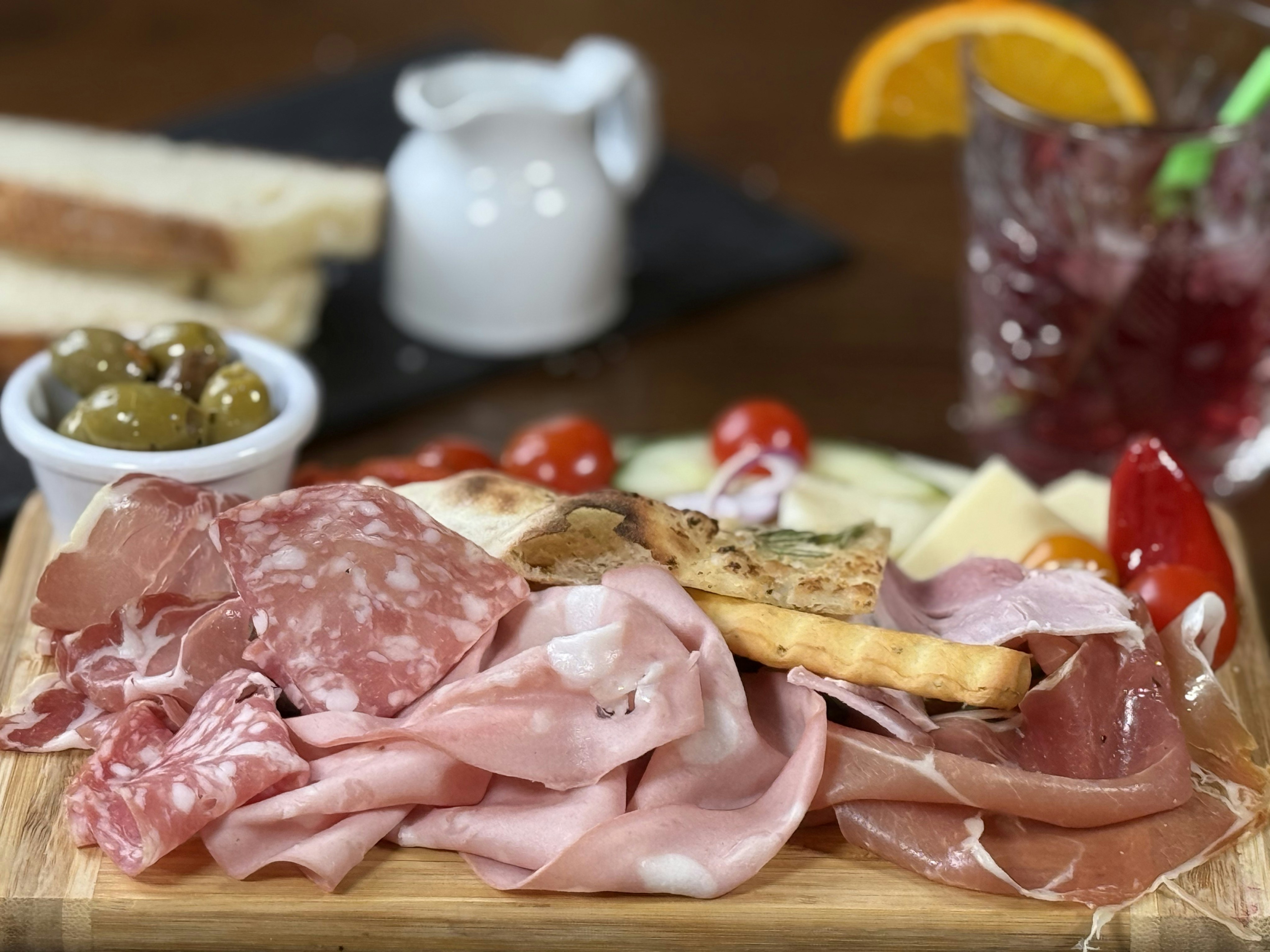 Charcuterie Mosaic: Pink Prosciutto and Crisp Bread on a Rustic Board