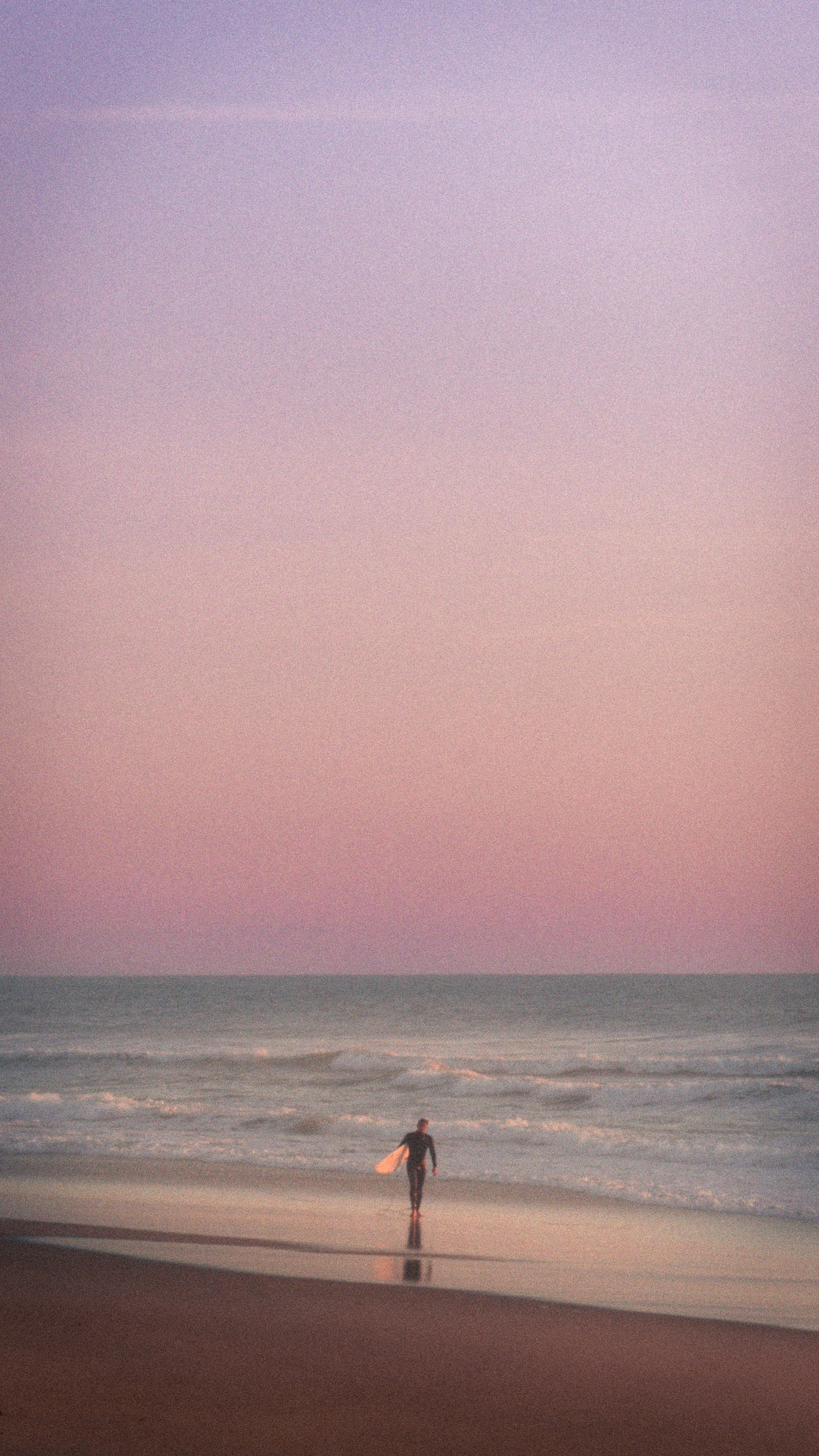 Surf Silhouette at Sunset: A Solitary Rider Wanders the Quiet Shore