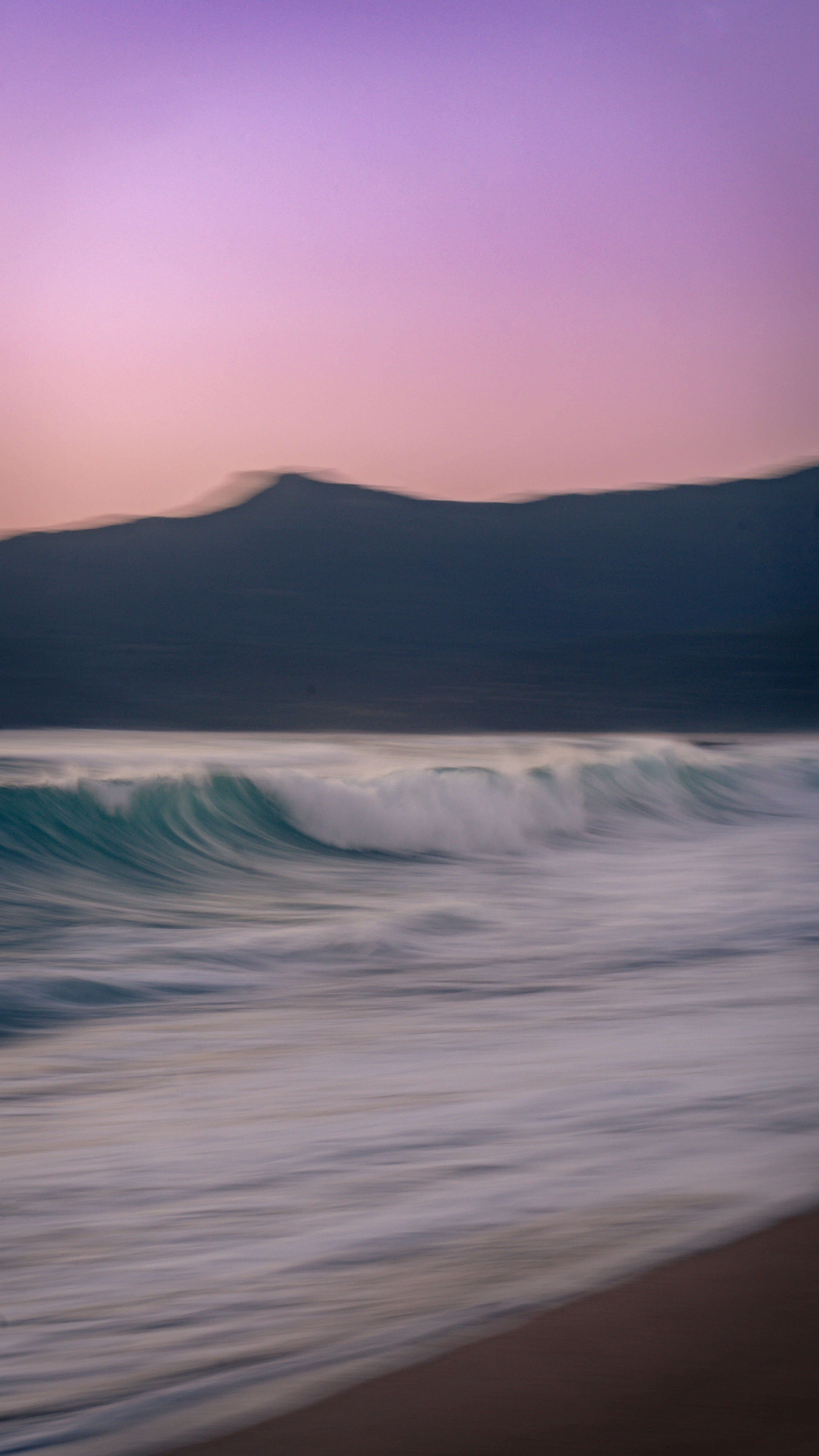 Pastel Tide: Silhouette of a Distant Crest at Dusk