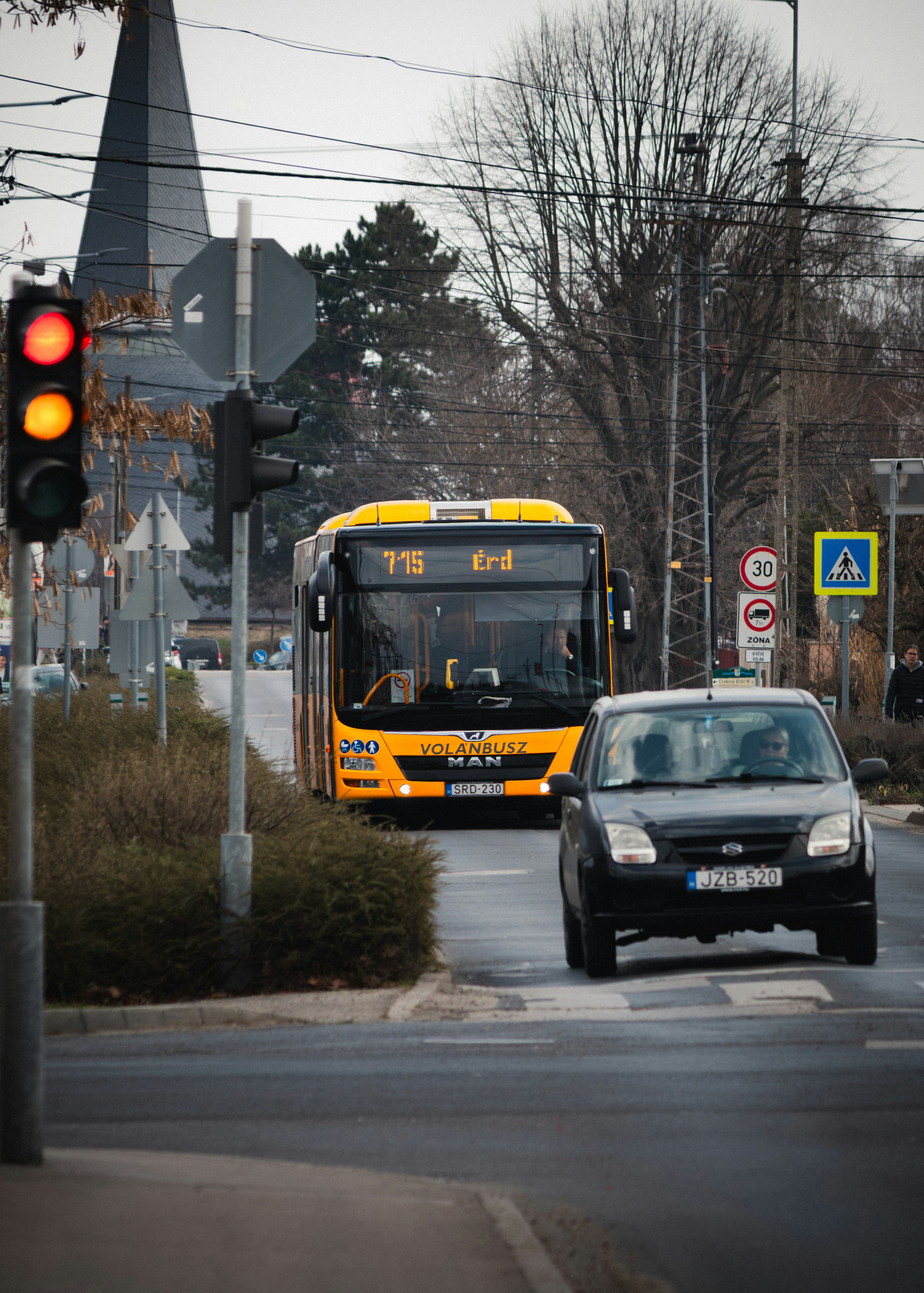 Amber City Bus Approaching an Urban Intersection
