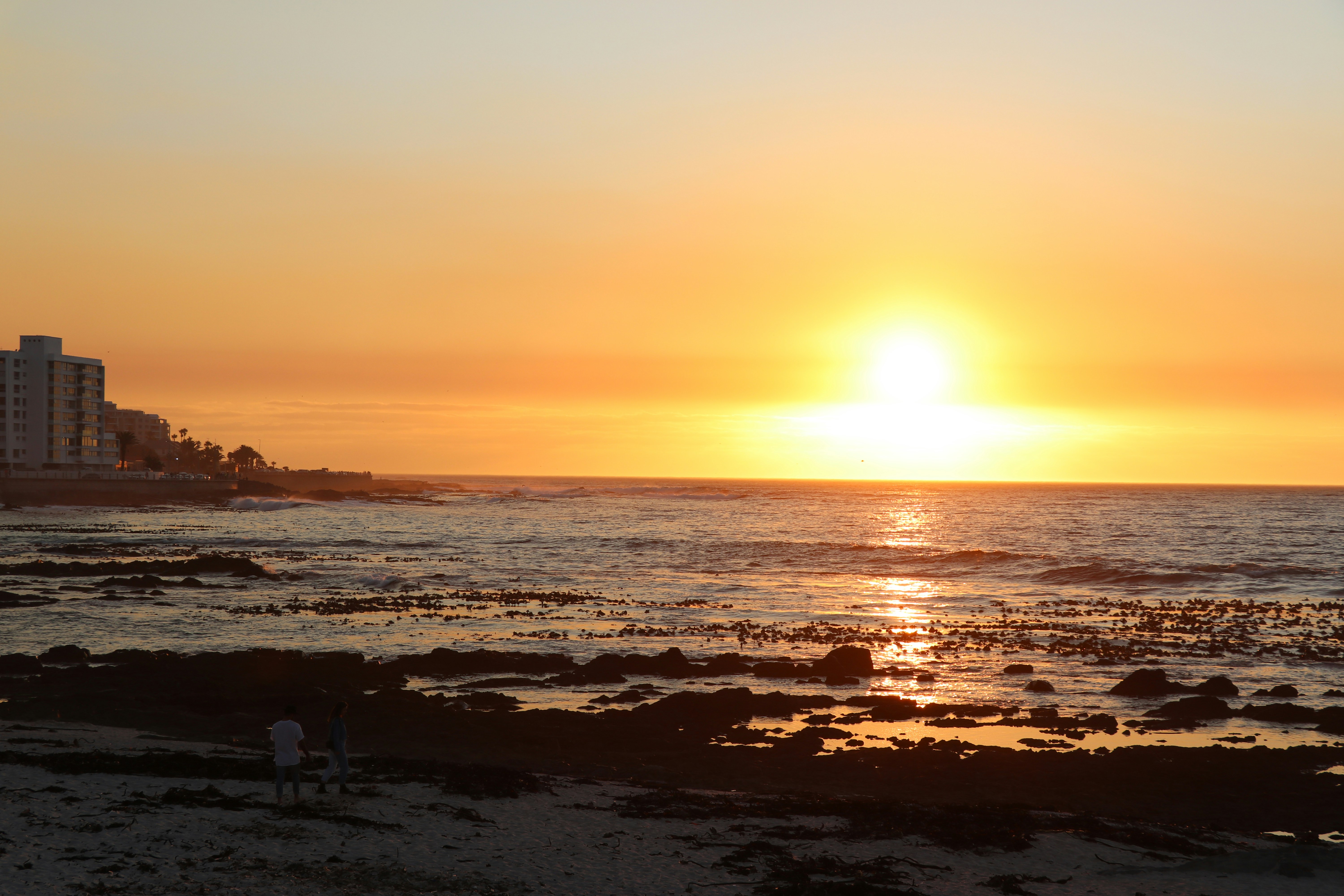 Sunset Over Rocks: Quiet Beach Where Tide Meets Light