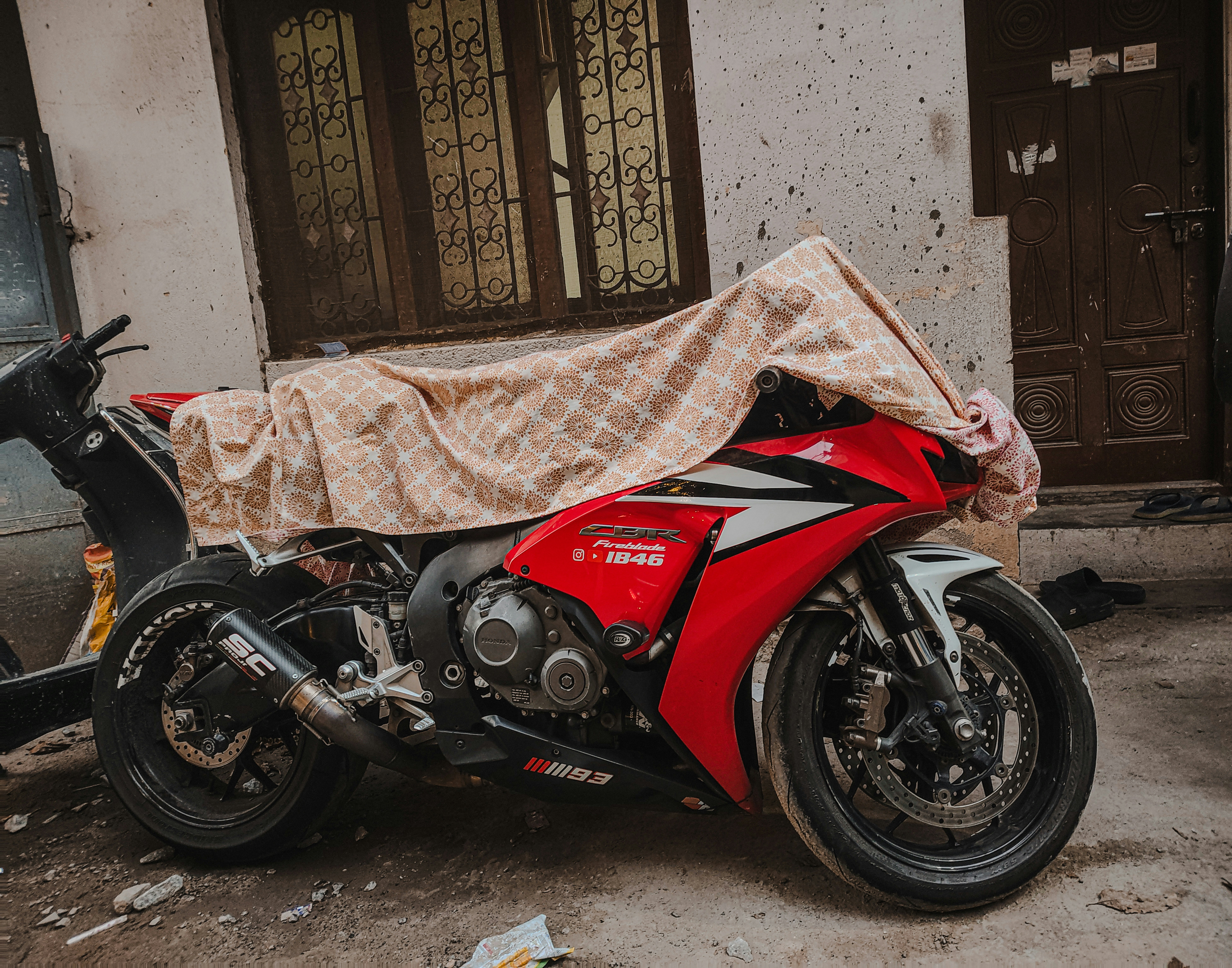 Hidden Fire: A Red Sport Bike Under a Shrouded Cover