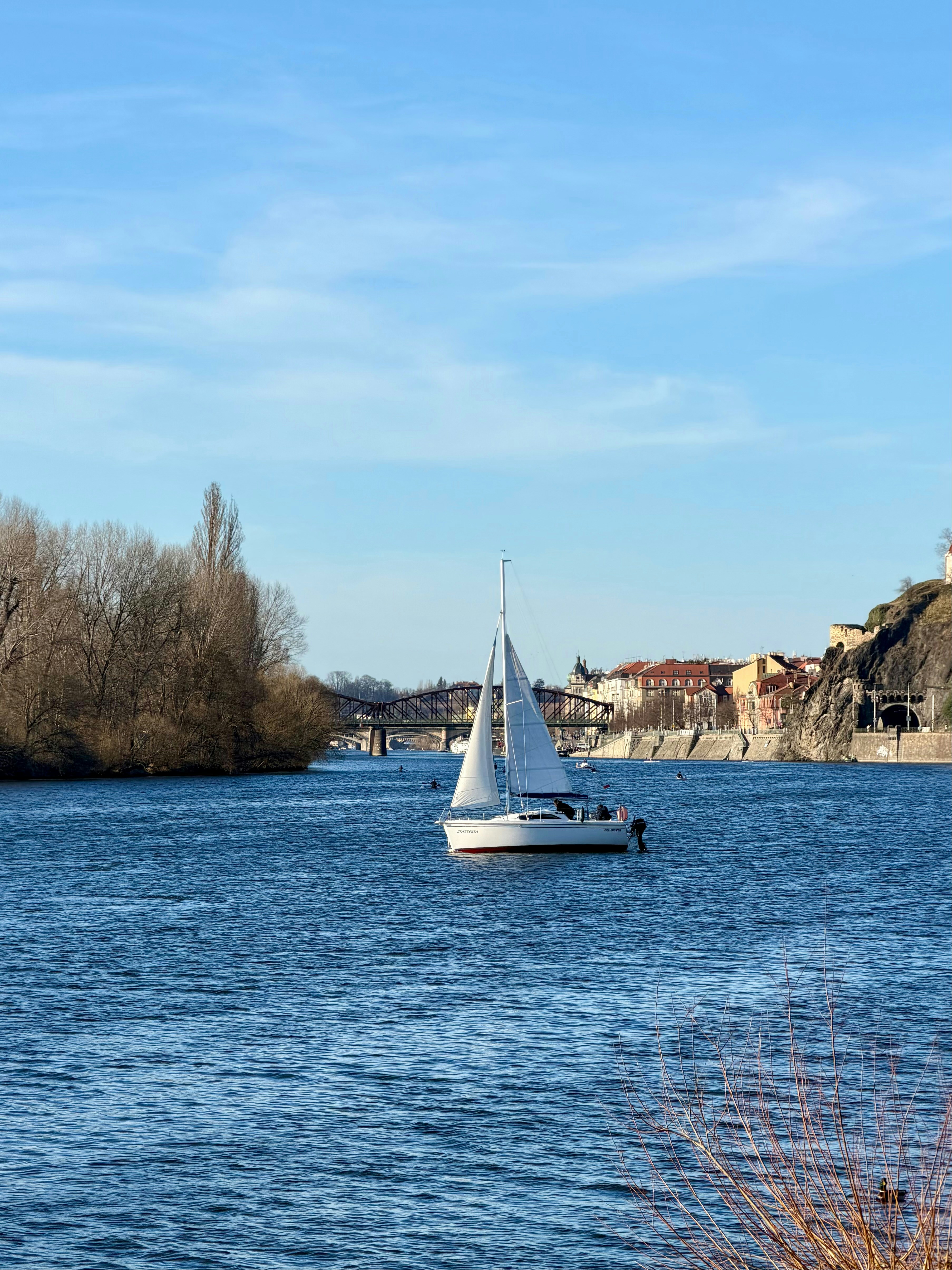 Sailboat in a Quiet River Bend Under a Bright Sky