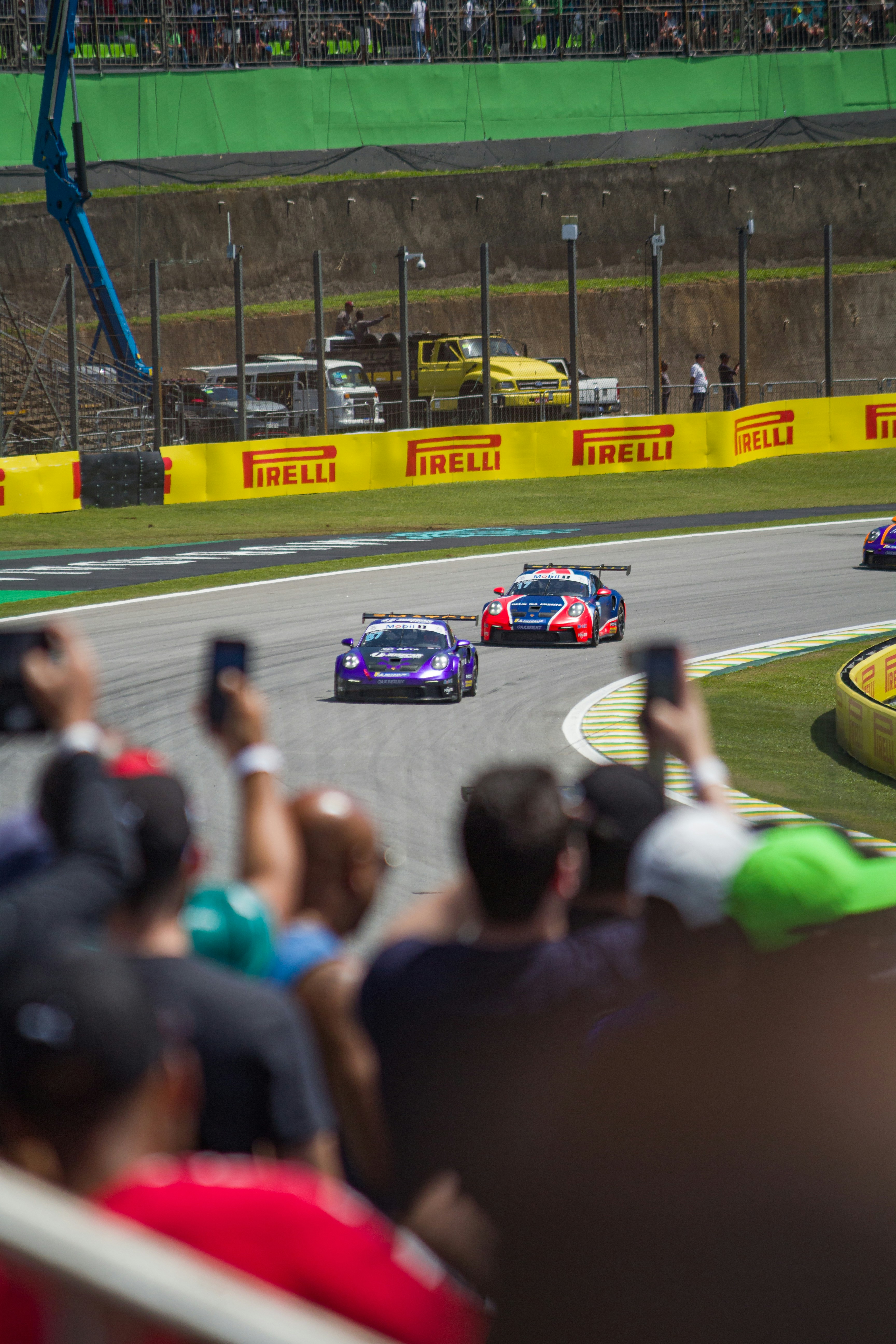 Pace Setters on the Crest: Racecars Charging Through a Cheerful Crowd