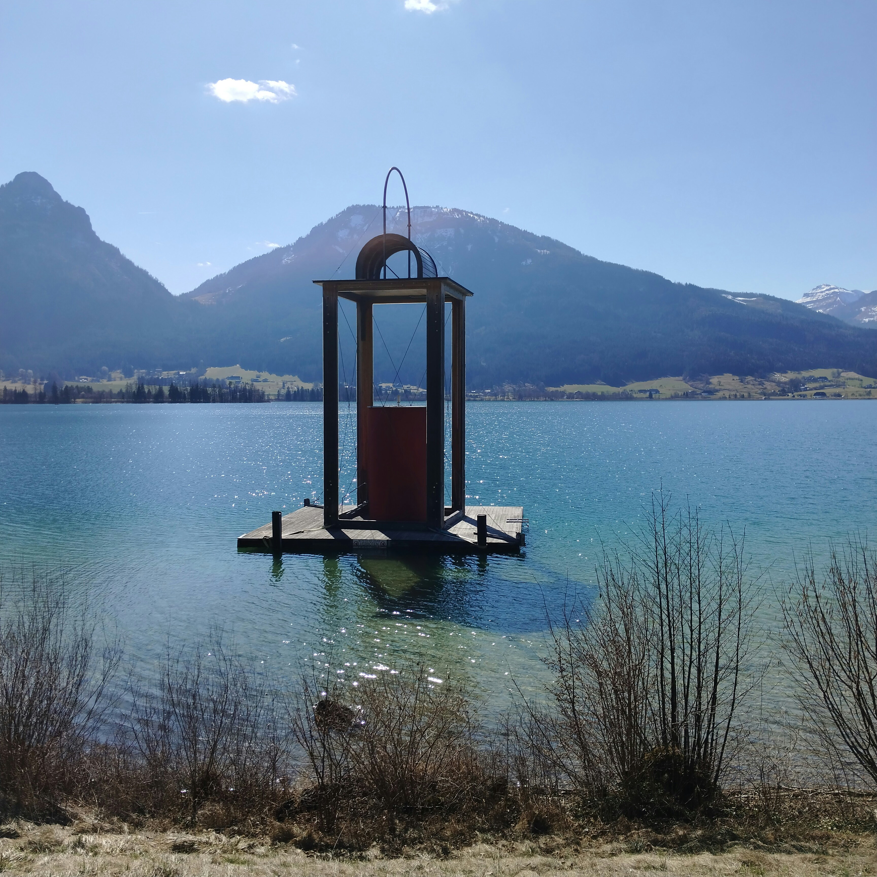 Floating lantern on a tranquil alpine lake with distant peaks