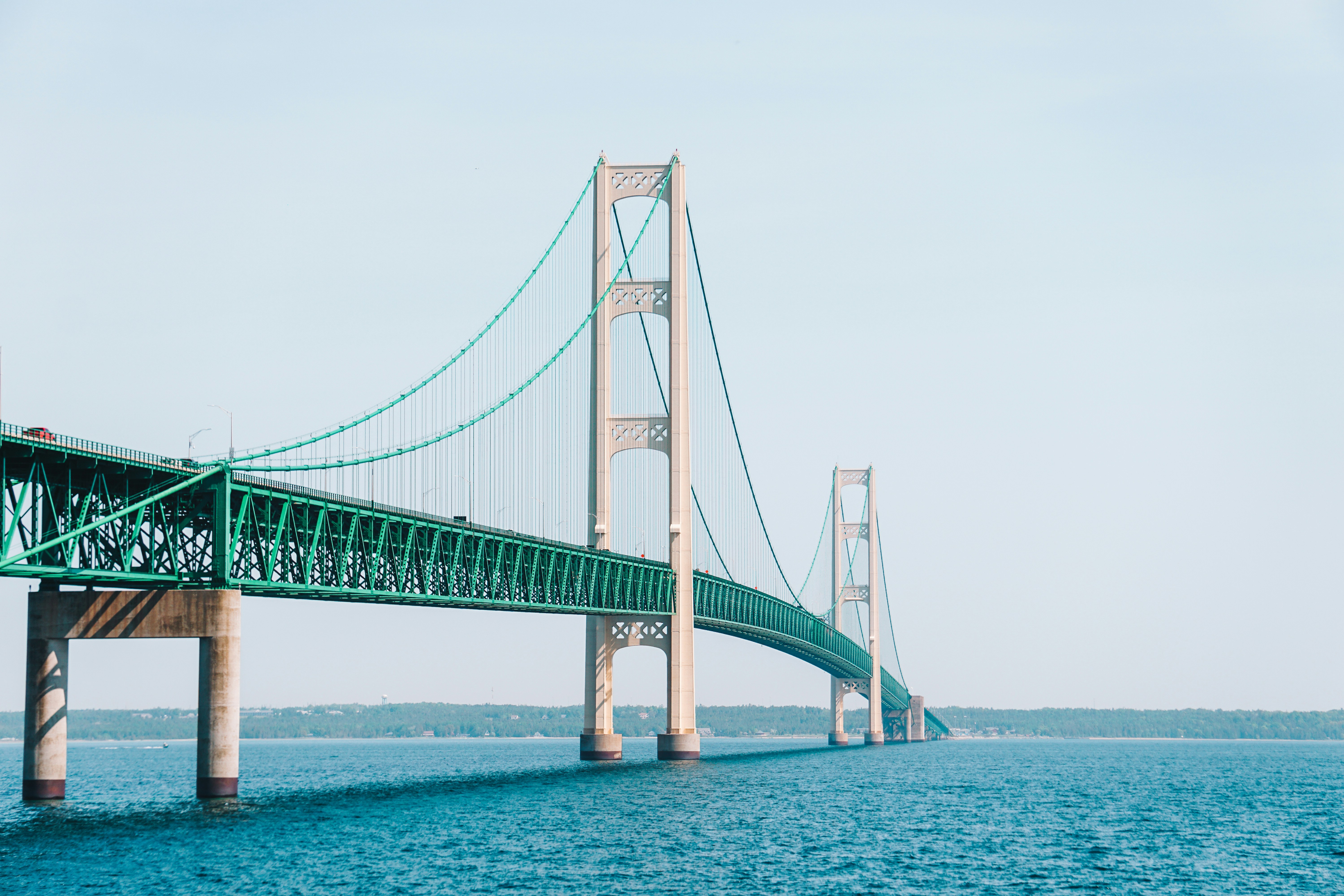 Morning Span: A Green Suspension Looming Over Quiet Blue Waters