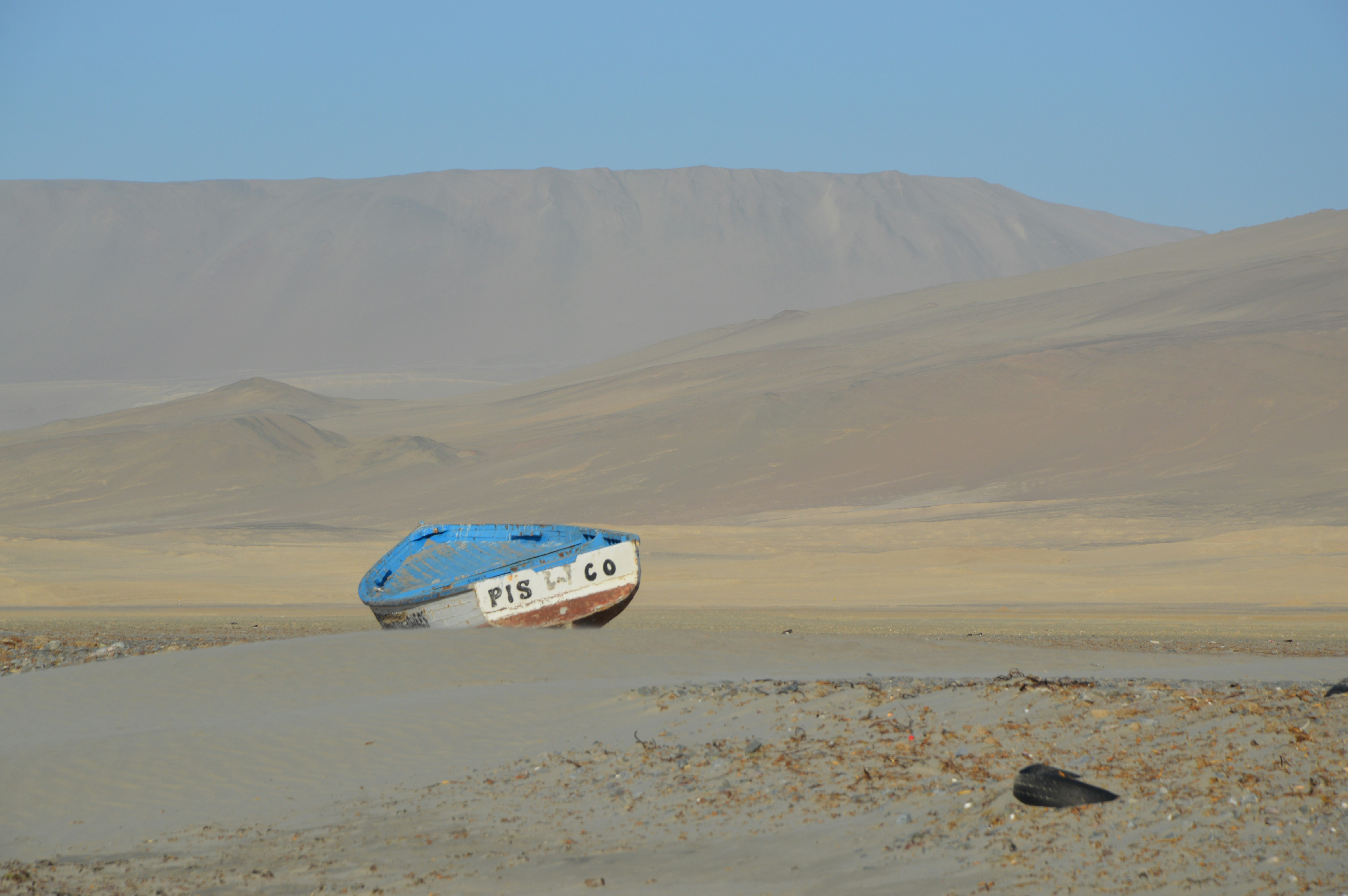 Deserted Boat Amid Dunes: A Solitary Vessel in a Quiet Basin