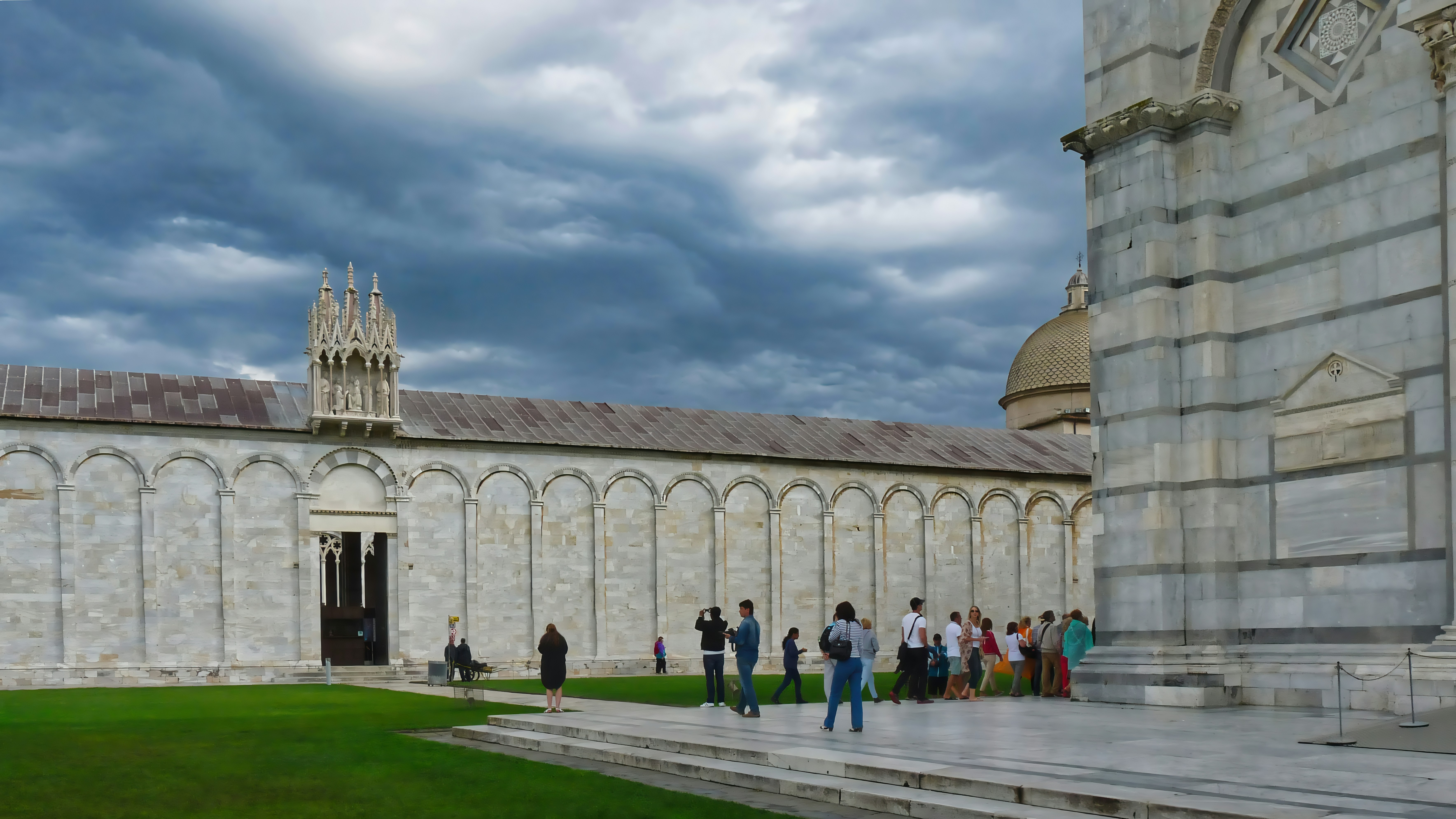 Visitors at a Late-Guilded Cloistered Corridor beneath a Stormy Sky