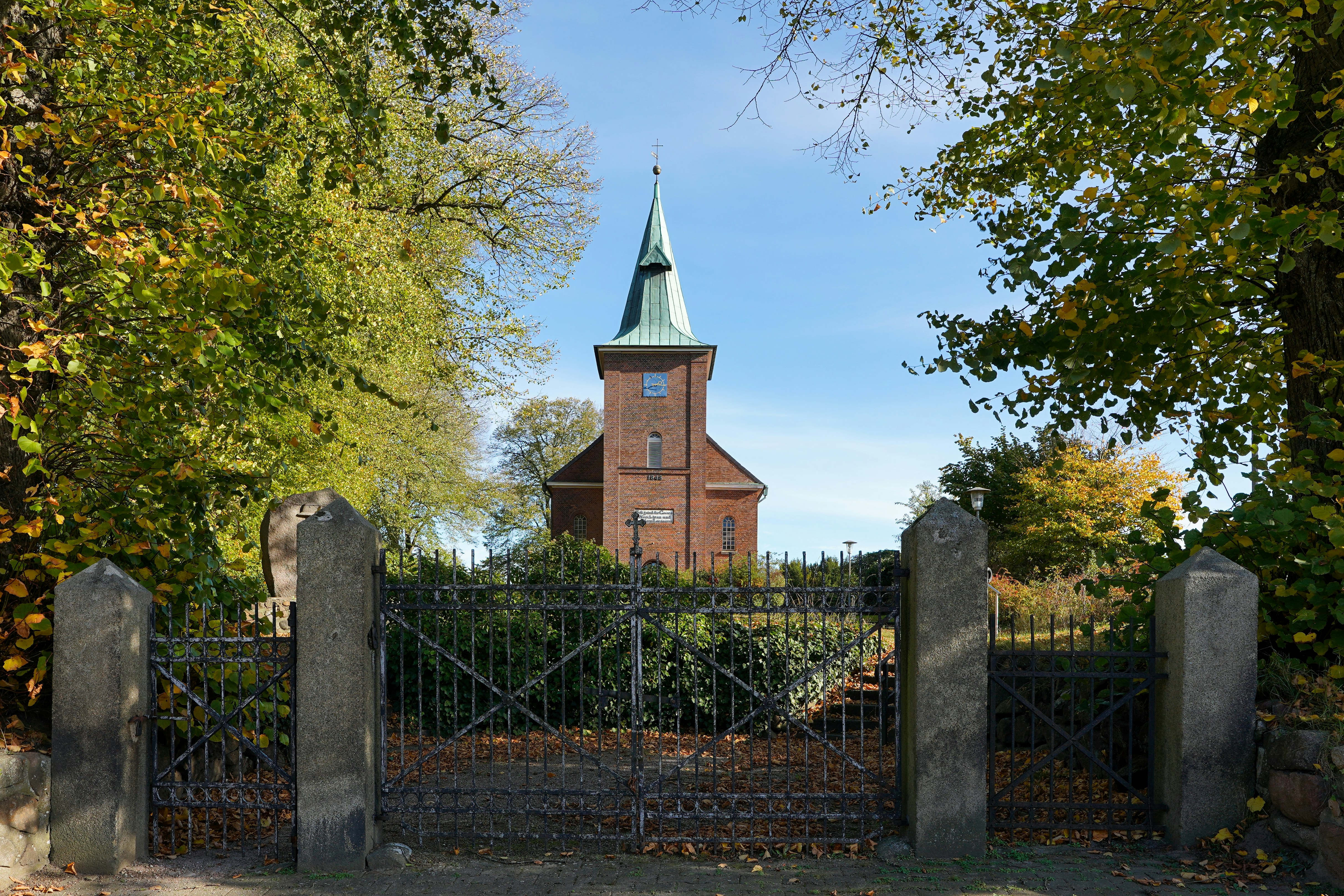 Gateways to the Chapel: A brick steeple rising Beyond Iron Fences