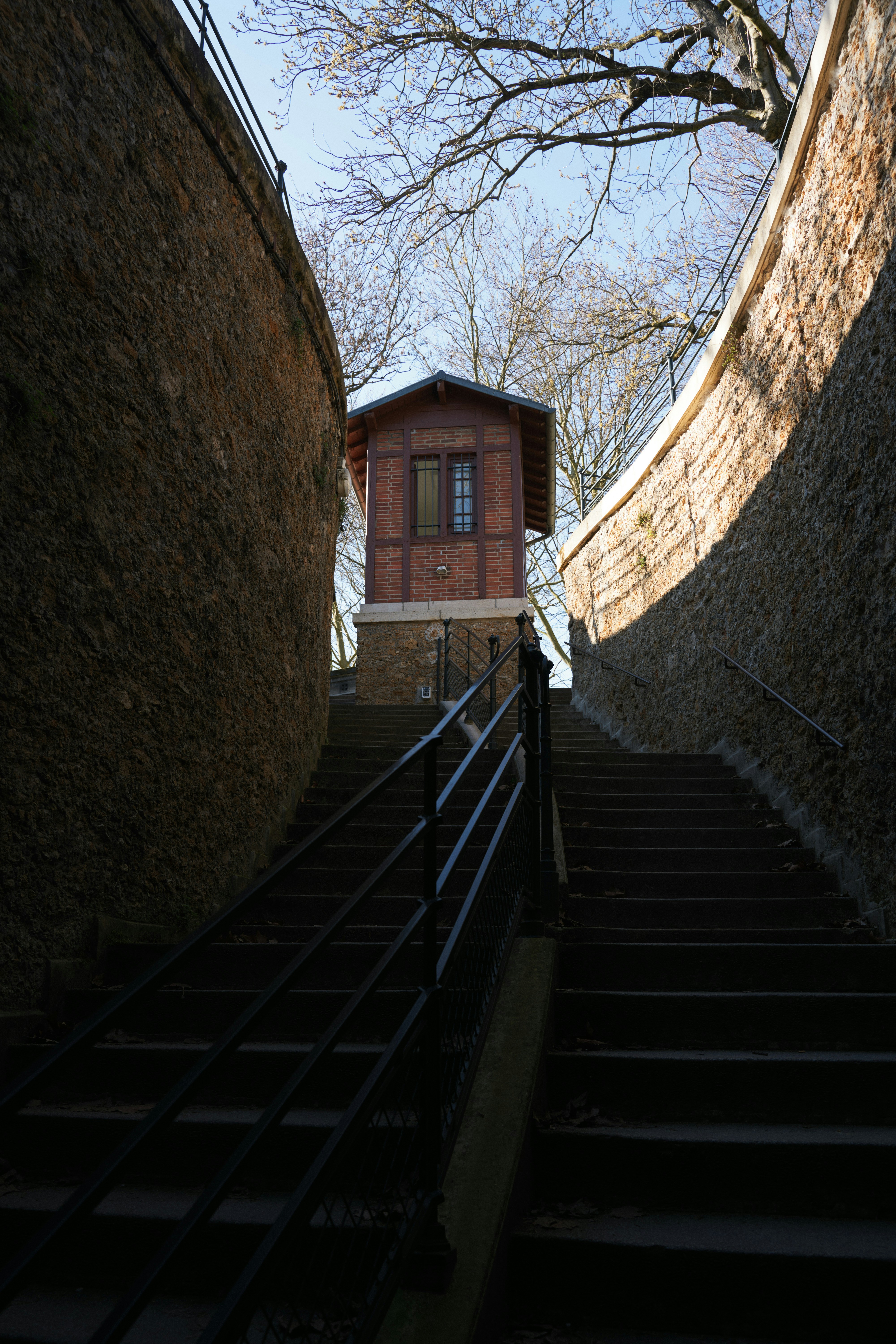 Upward Ascent to a Tiny Lodge: A Staircase Between Timeworn Walls