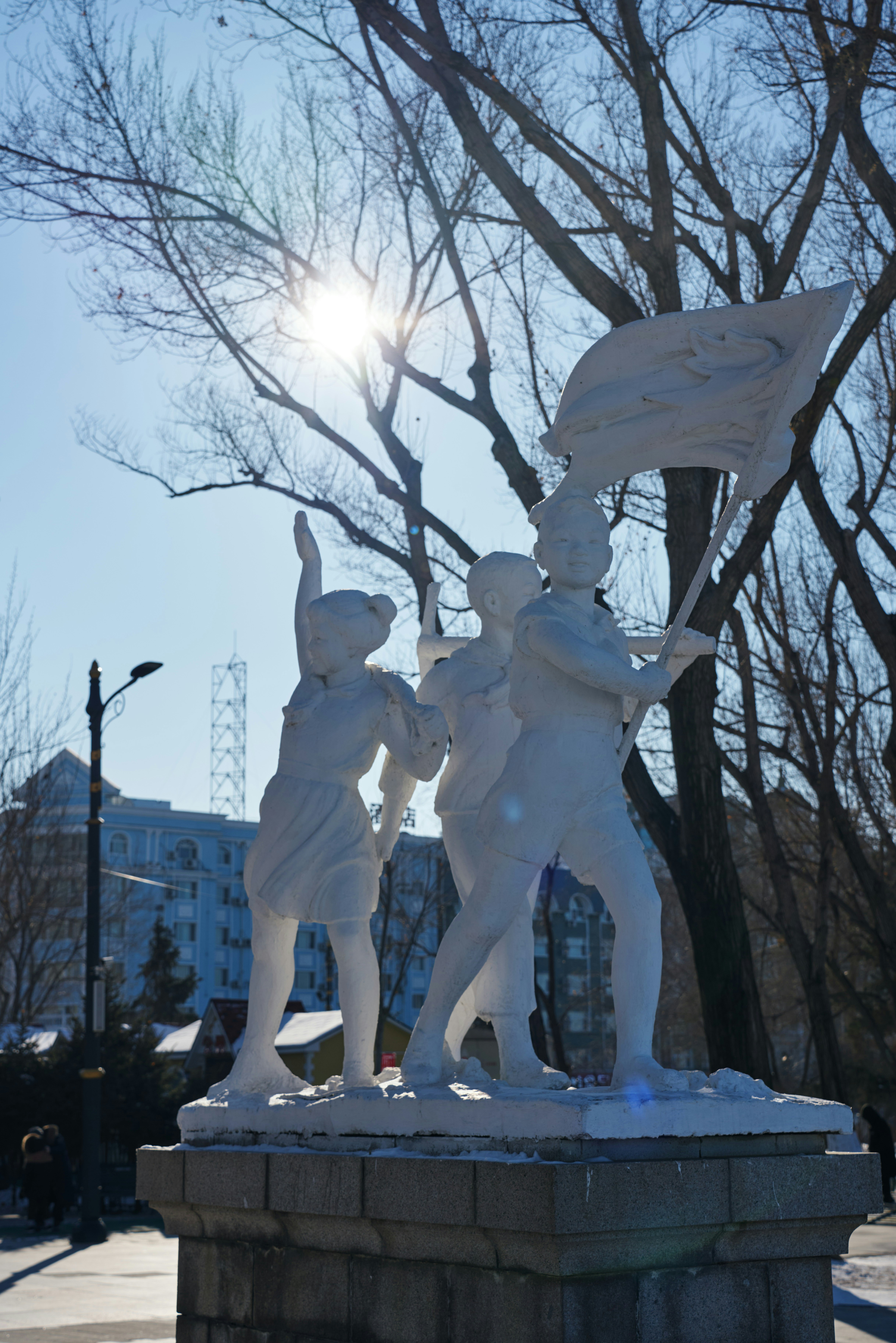 White Figures in Winter Light: A Statue Quartet in a City Park