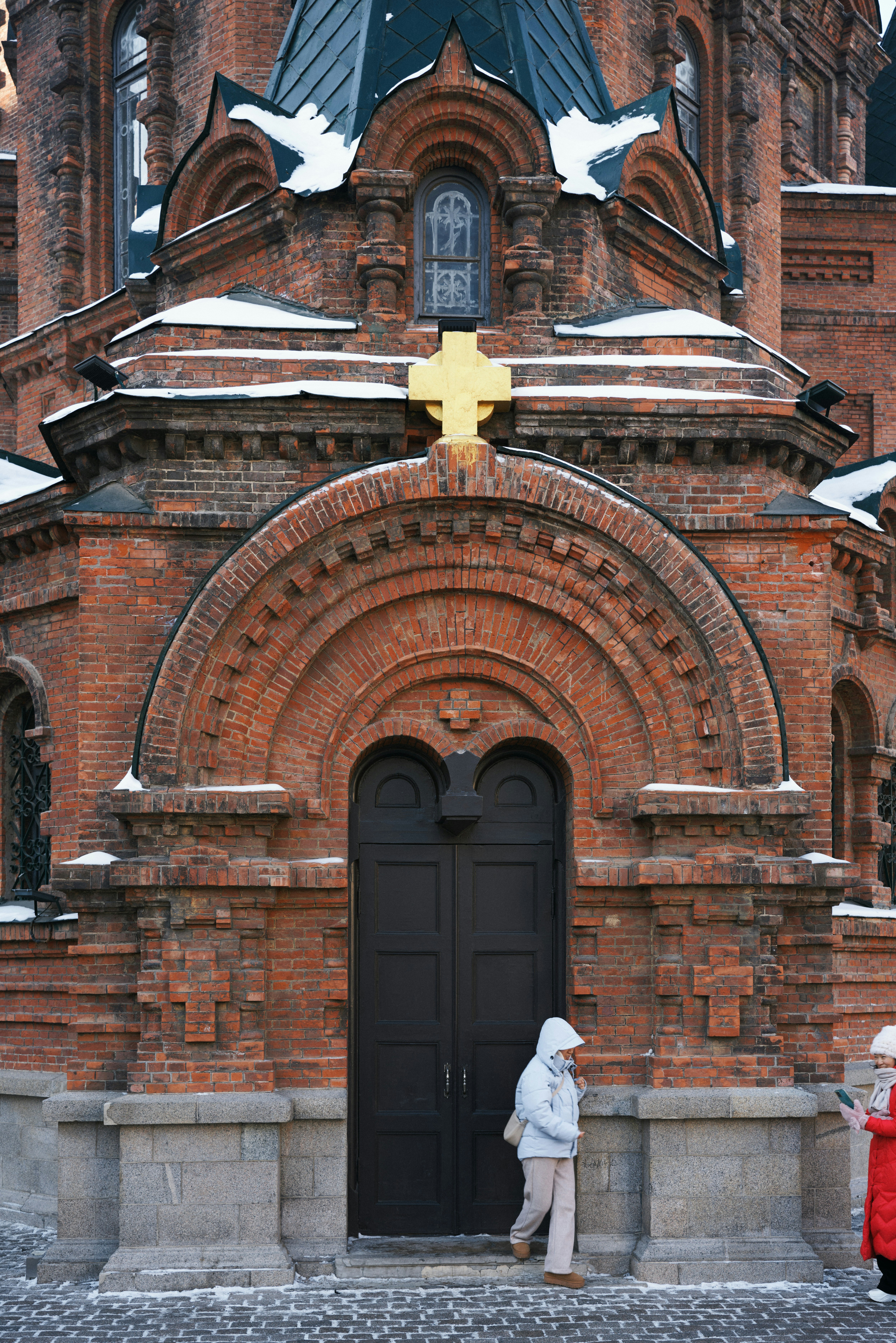 Winter at the Brick Facade: A Quiet Walk by the Cathedral Door
