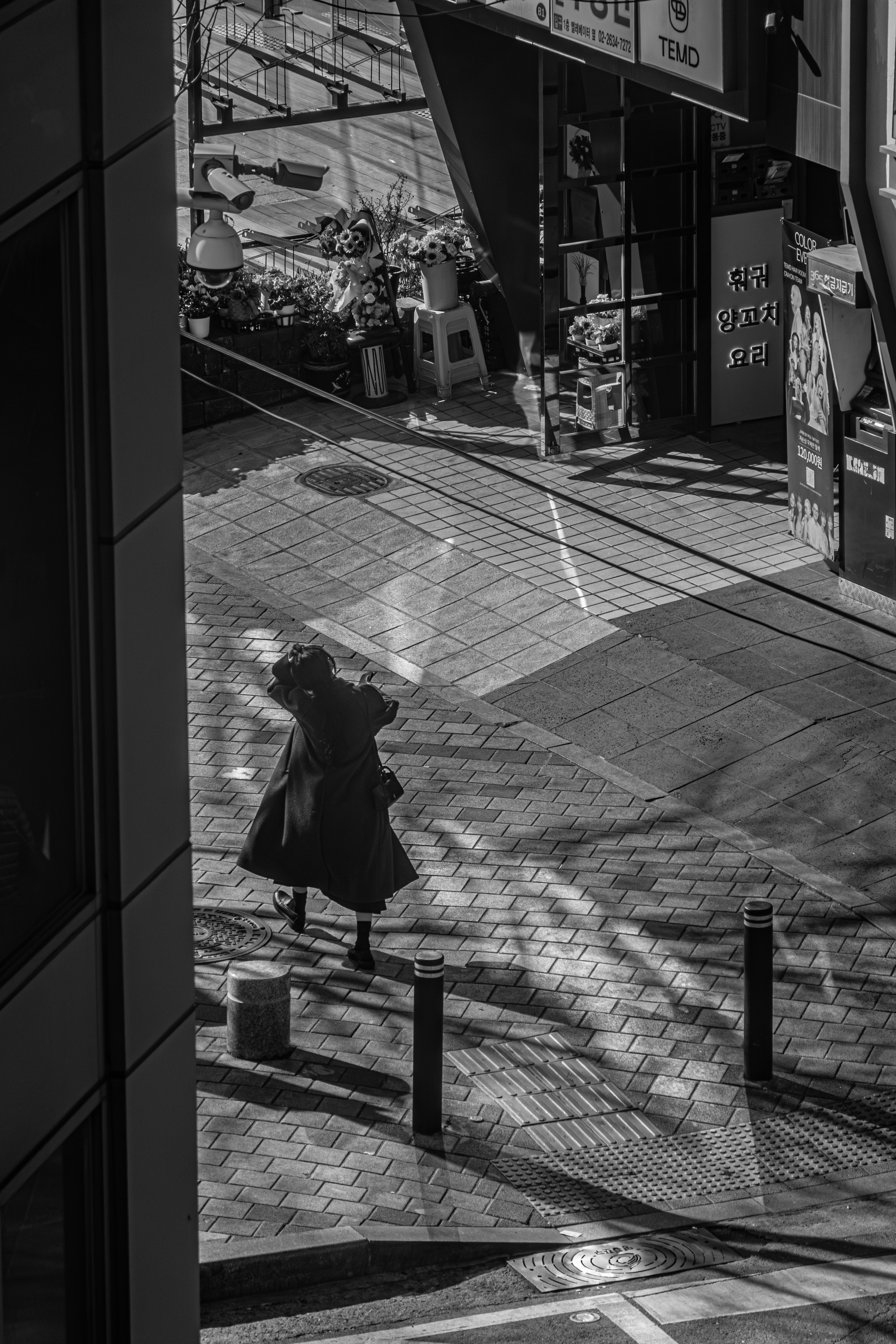 Shadowed Figure in Motion Across a Sunlit Street