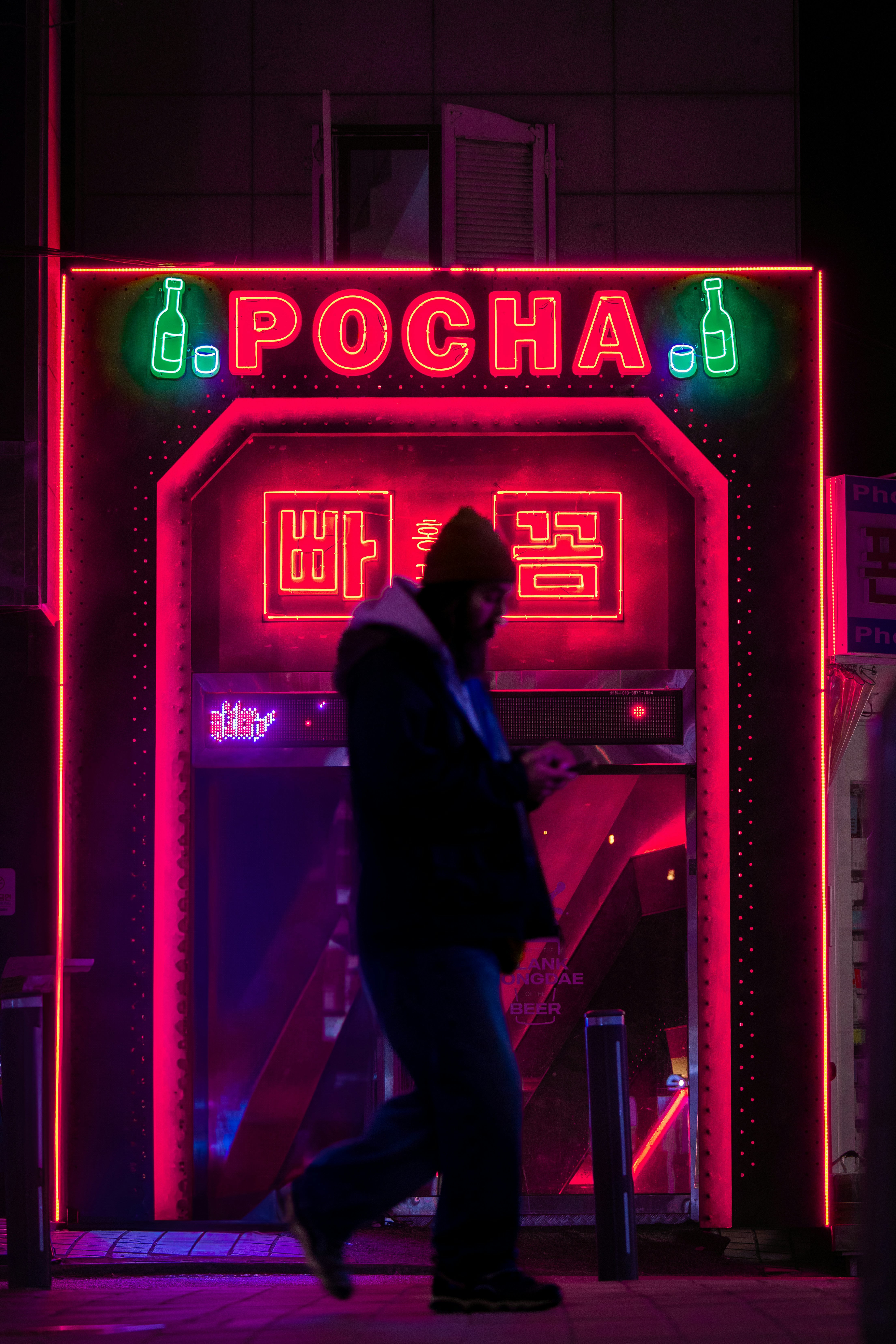Neon Veil: A Quiet Figure Beneath the Poka-Door Glow