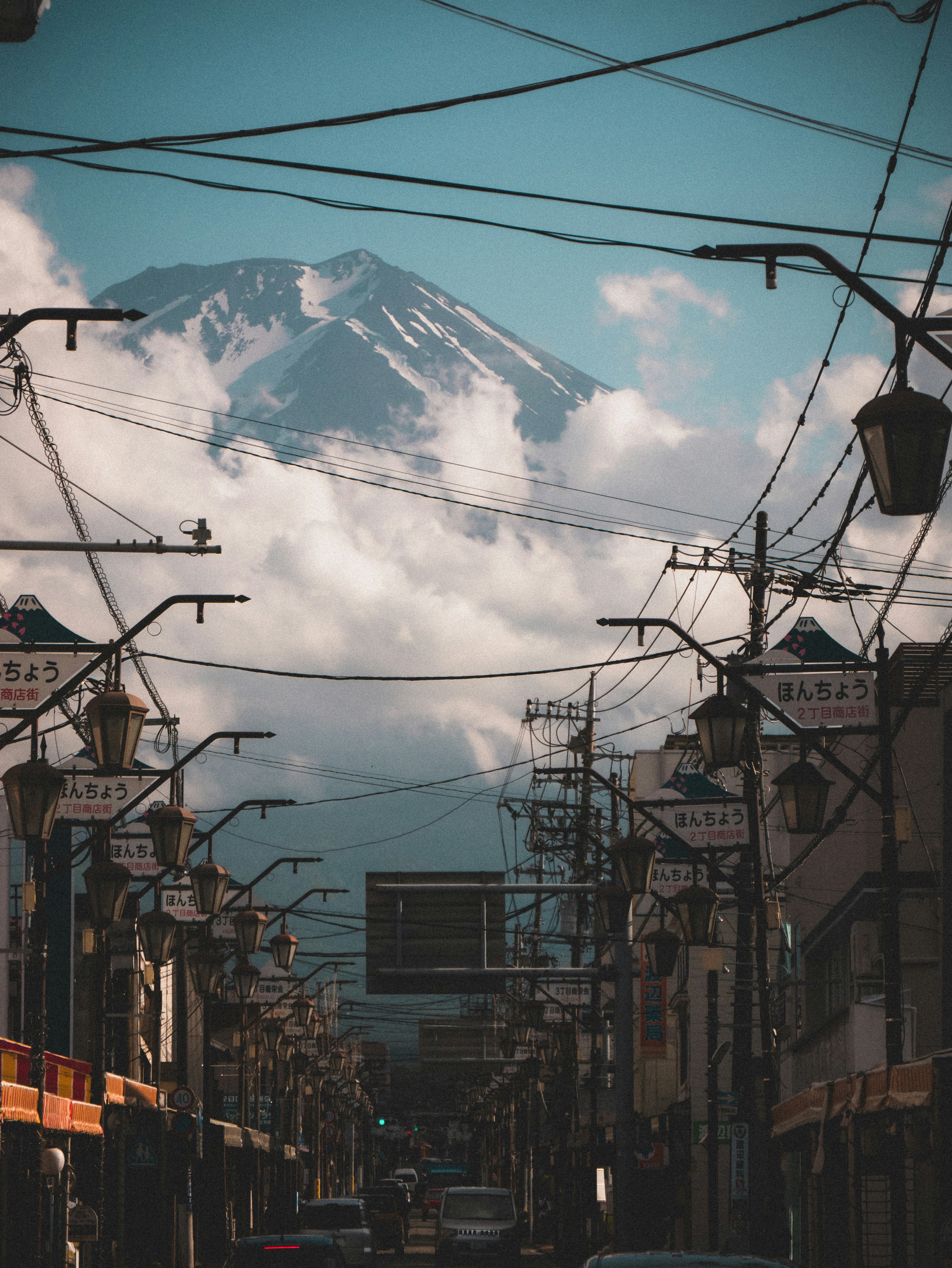 Cable Crowns and Mountain Backdrop: A Quiet Street Under Cloud-Led Majesty