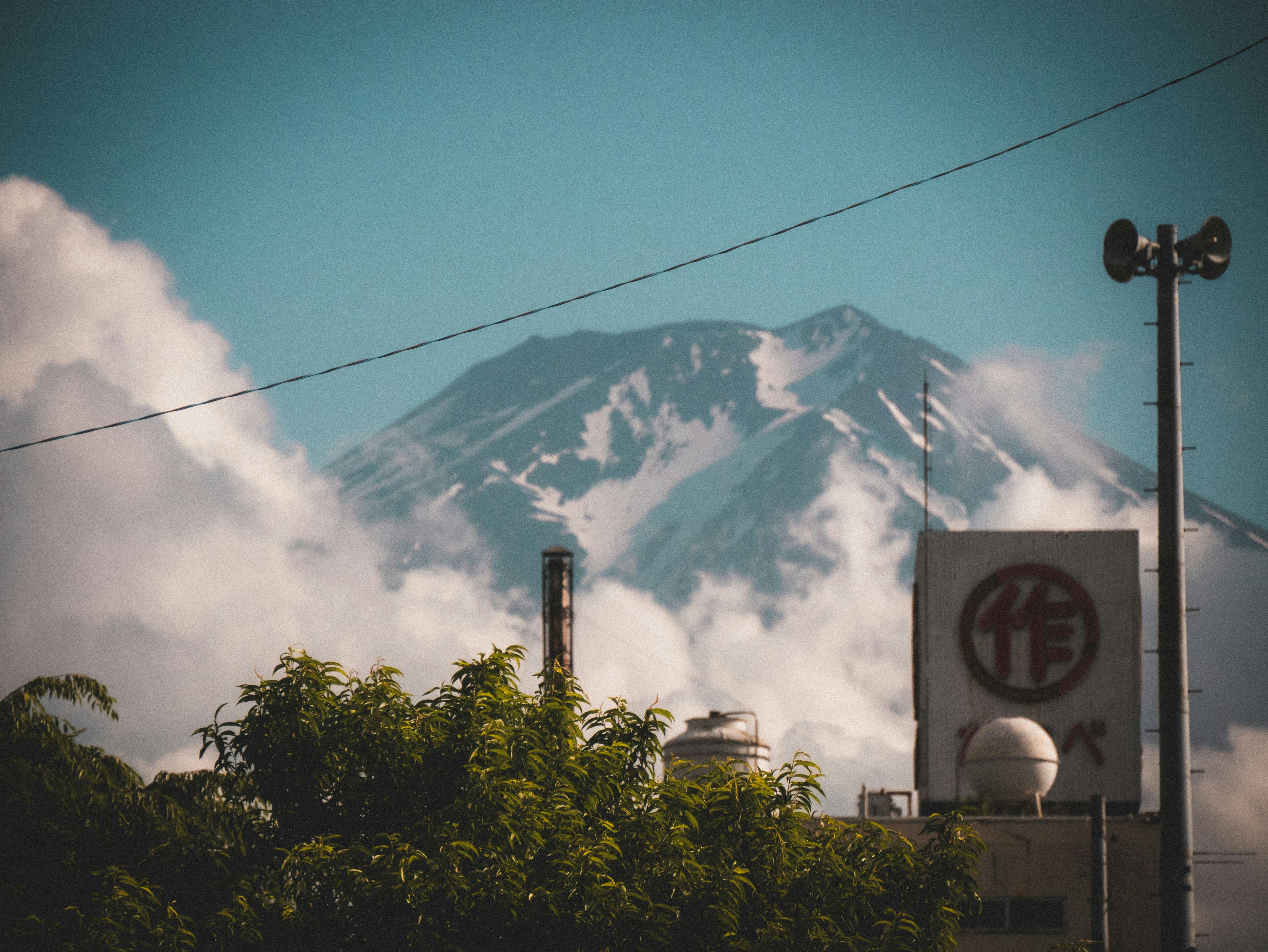 Mountain Crown Over Factory Rooftops
