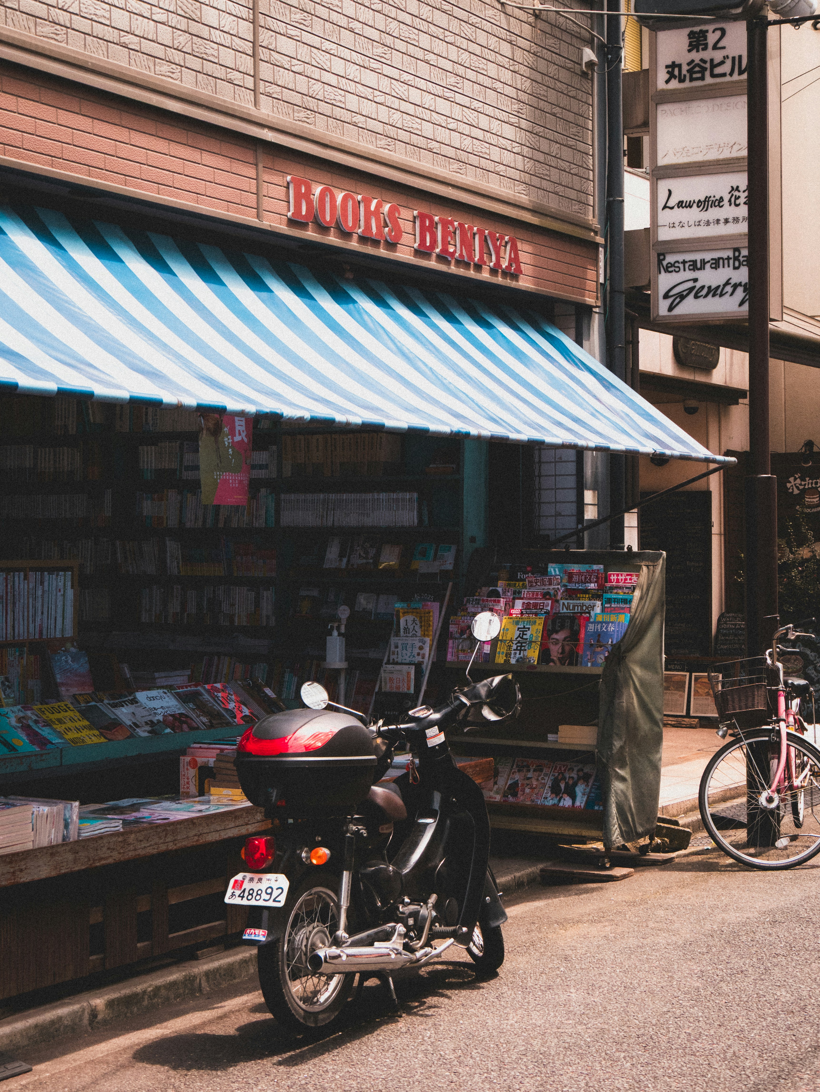 Blue-striped Awning Over a Quiet Street Bookshop Stalls
