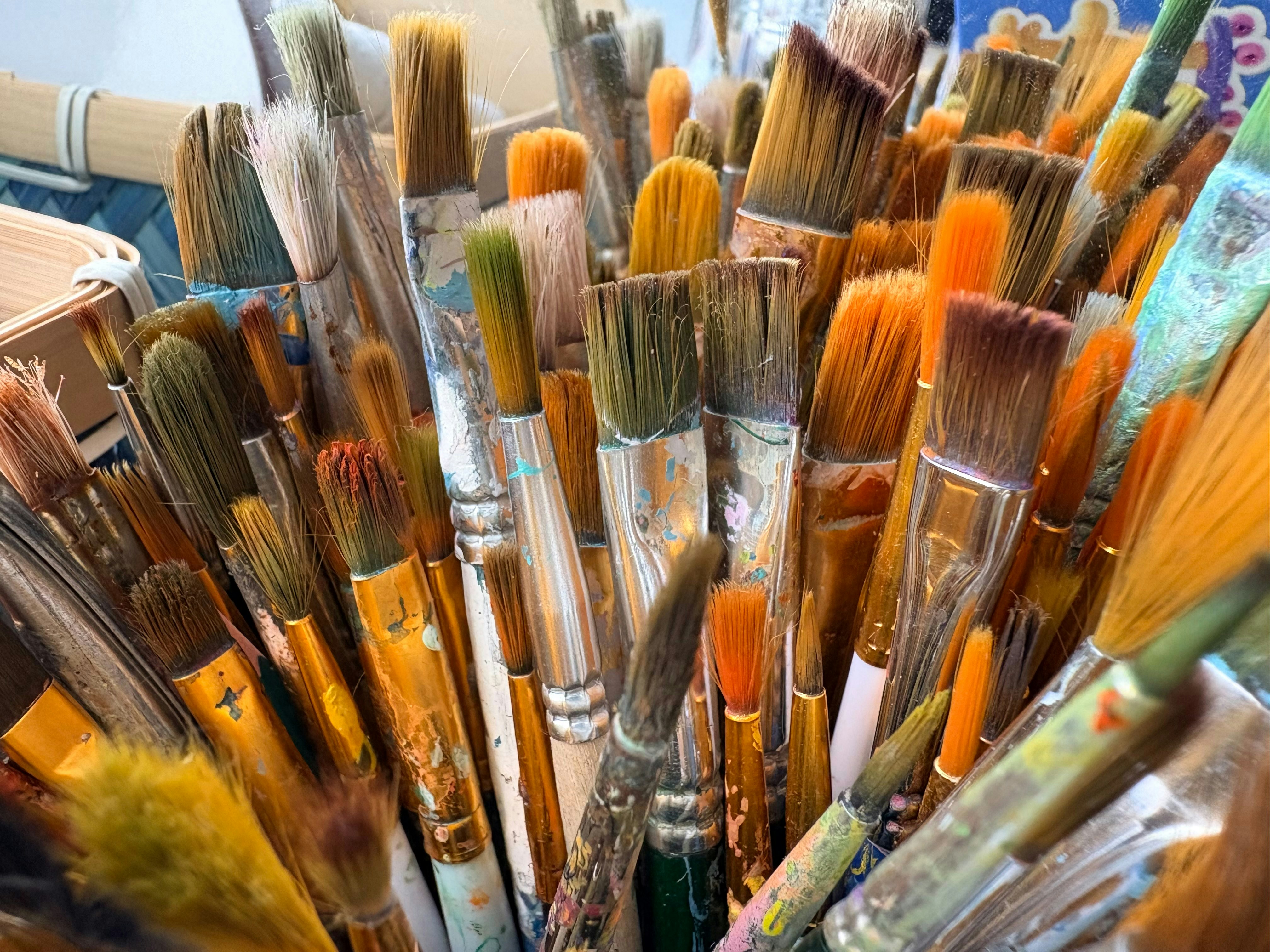 A collection of assorted paintbrushes in a container.
