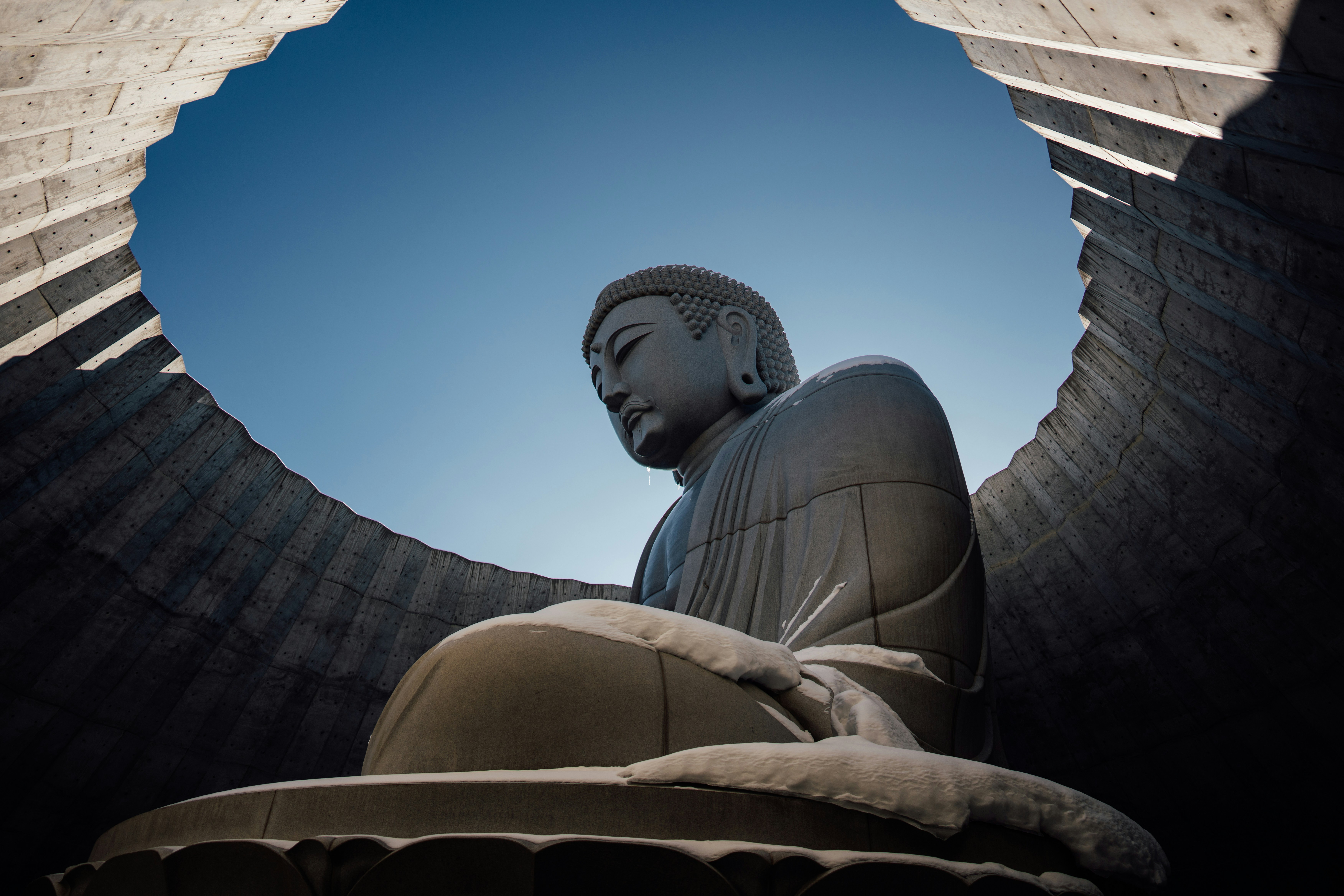 Buddha in the Circular Sky: A Reverent Silhouette Within the Stone Ring