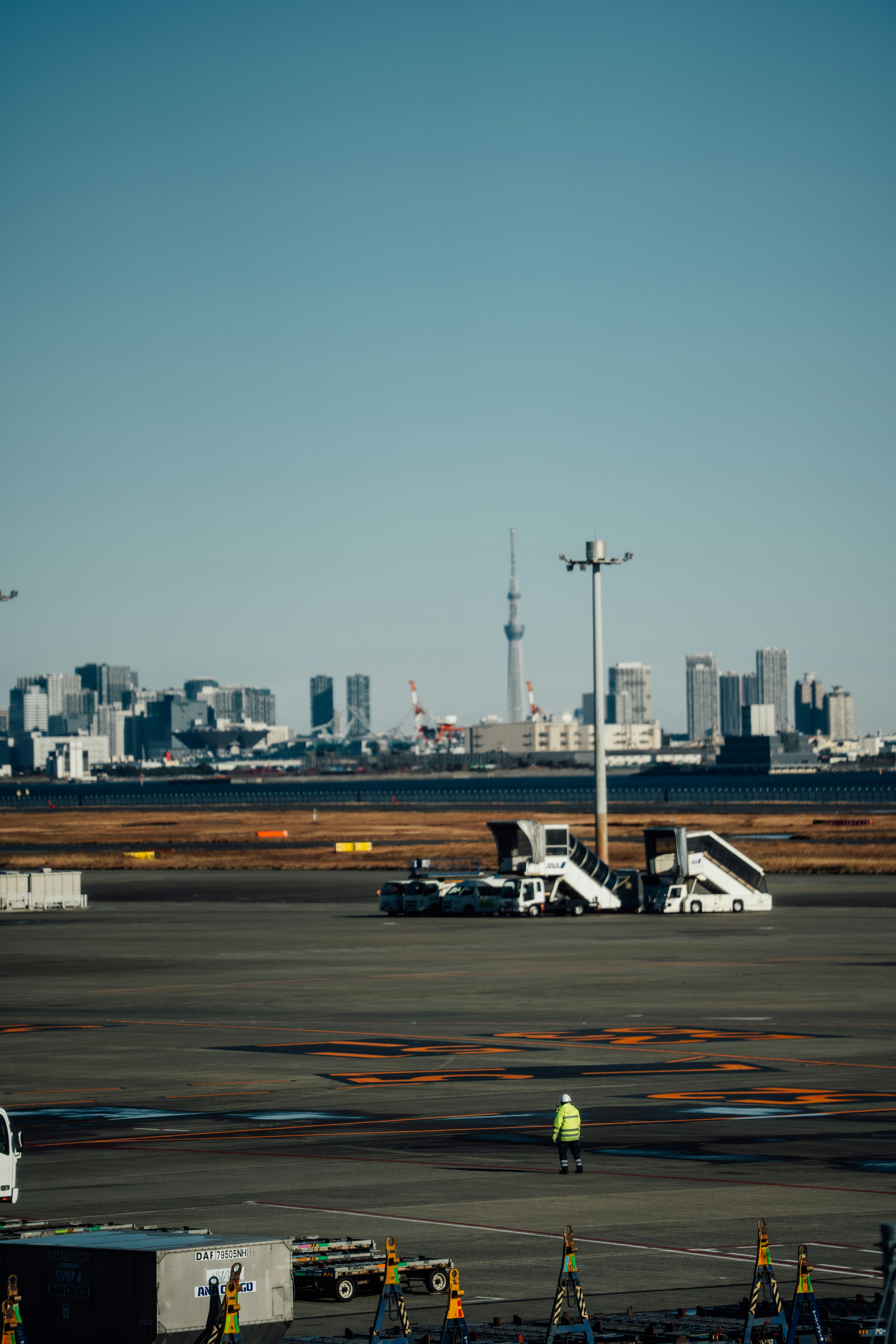 Ground Crew at a Quiet Airport: Aerial View into the City Horizon