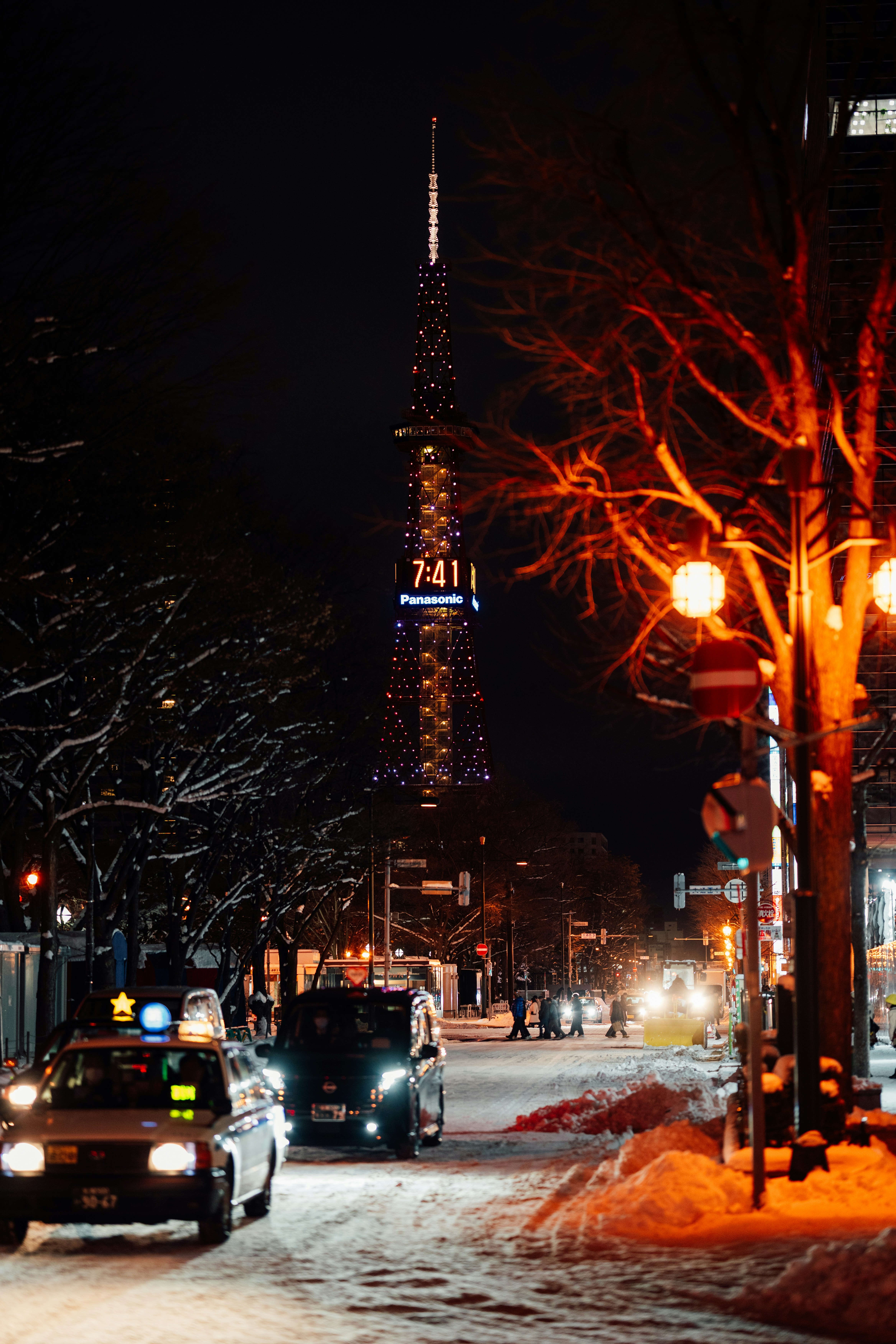 Tower Glow Over Snowbound City: Night Drive Toward the Neon Spire