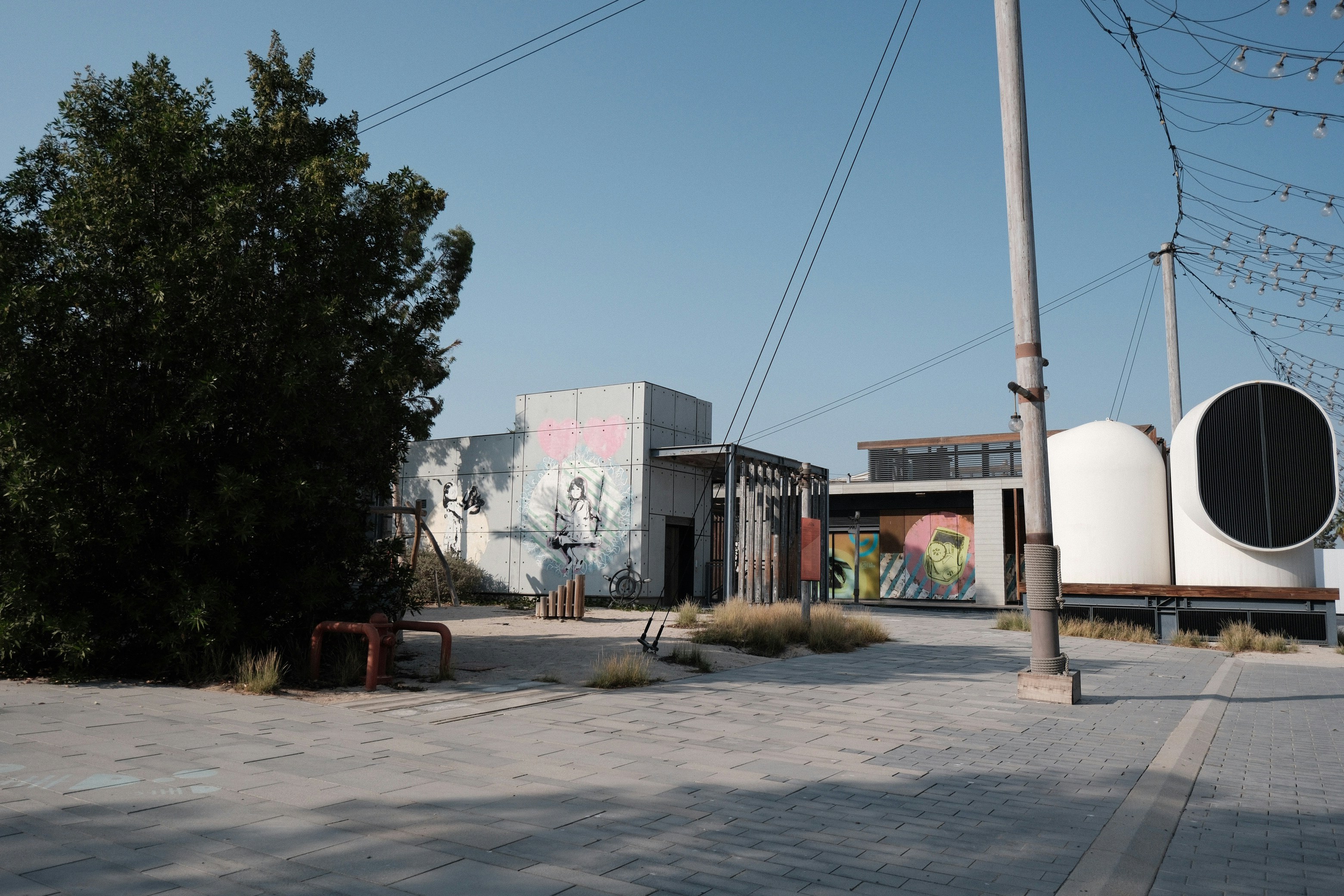 Urban mural beacon: a quiet plaza framing a gallery of graffiti and geometric structures