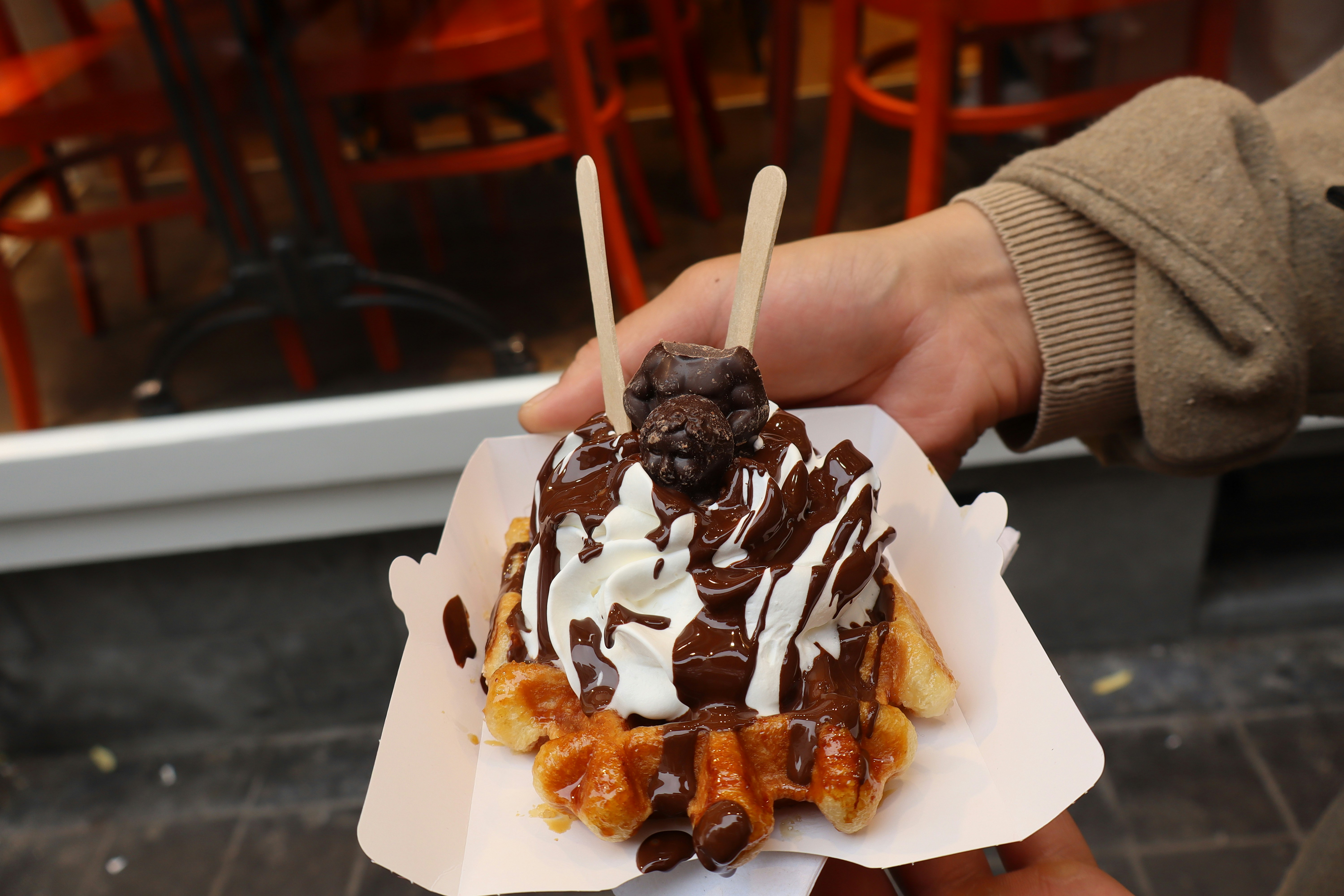 Chocolate-swirled street-side dessert crowned with whipped cream and churros