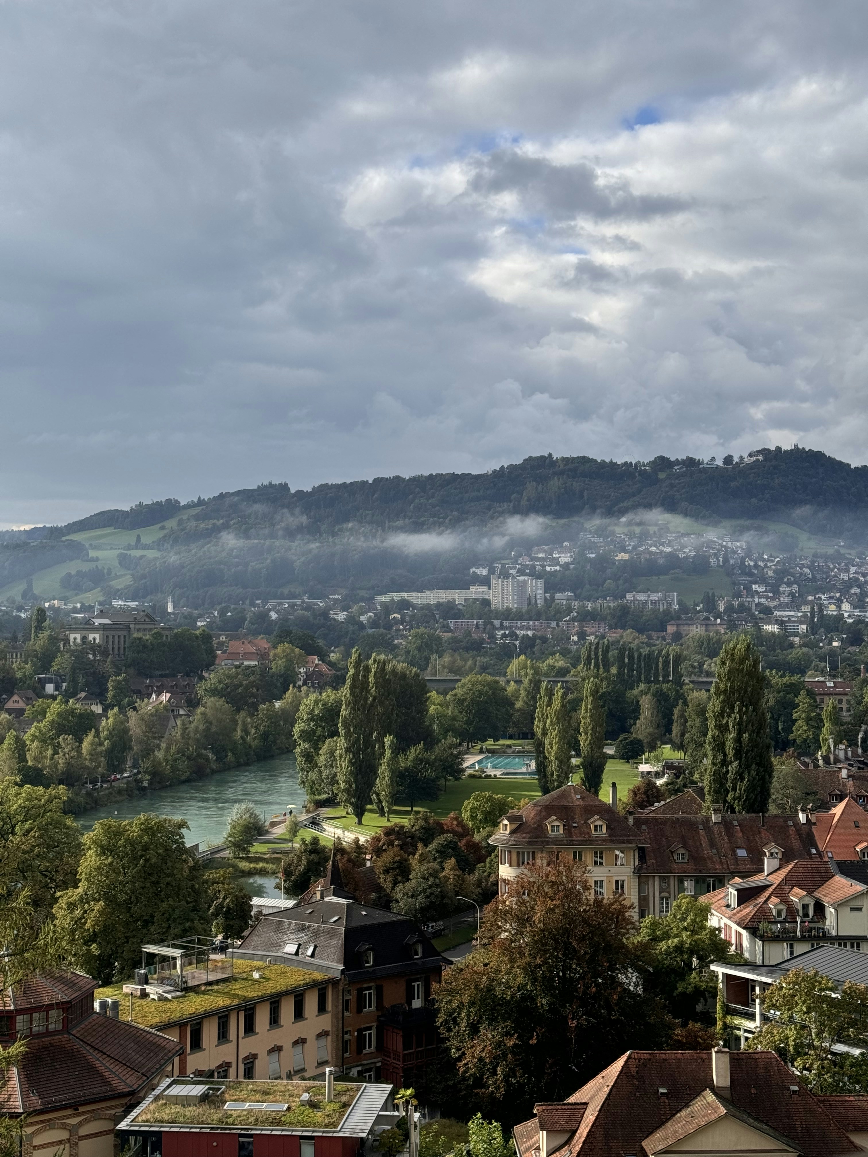 A Swiss Town Resting by the River under Layered Clouds