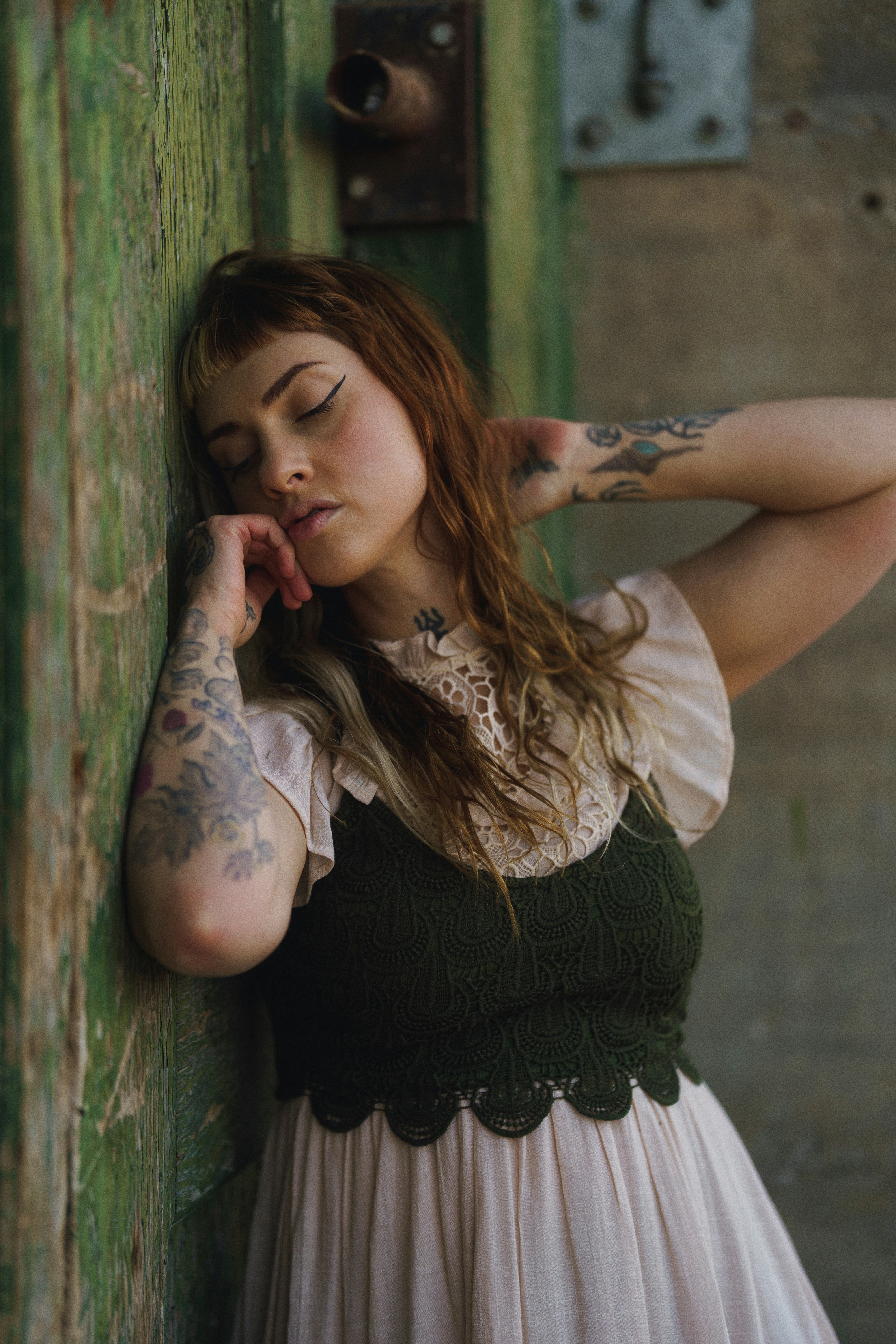 Her Quiet Repose Against Weathered Green Wood