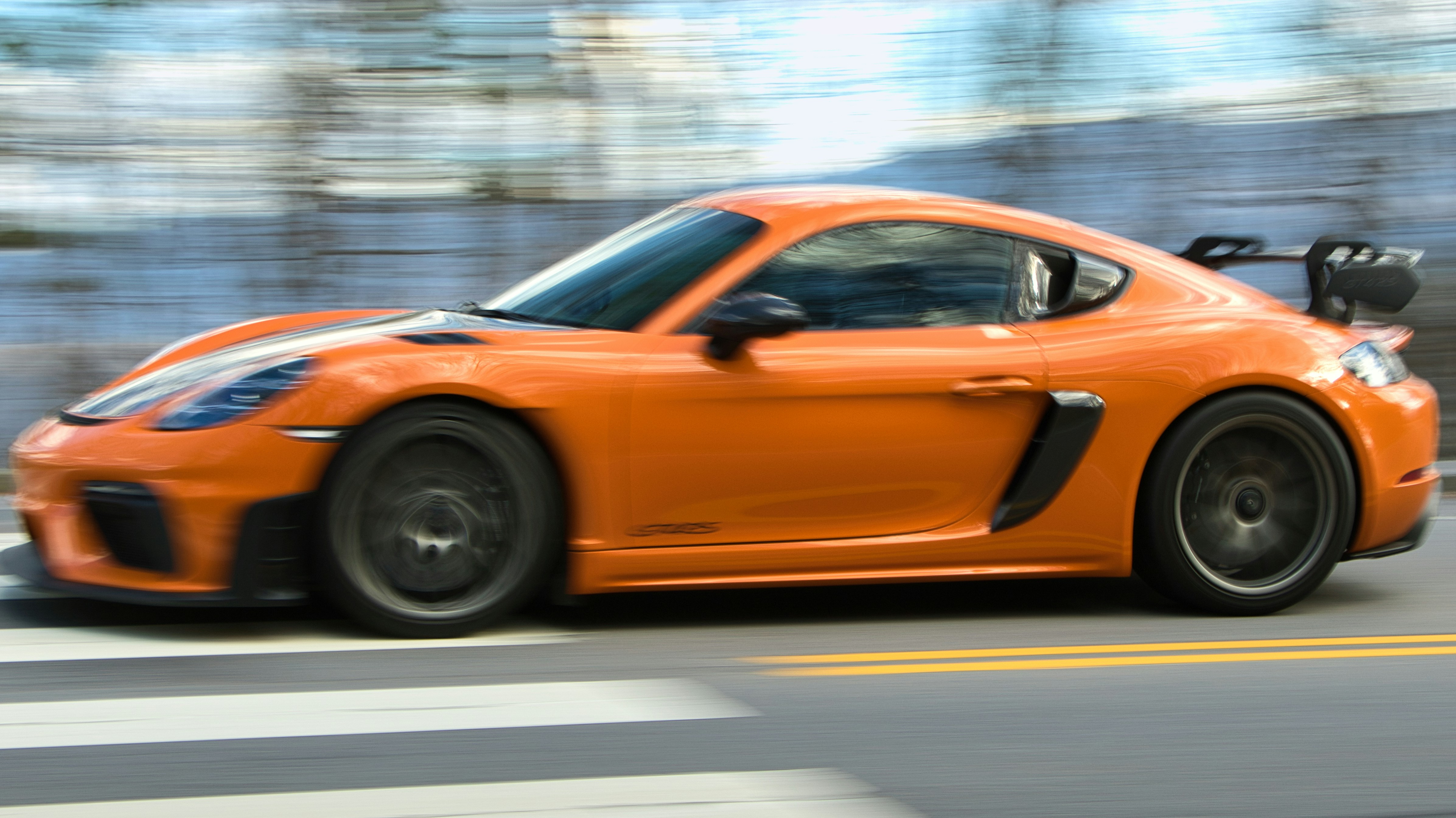 Orange blur: a Porsche in motion on a city street