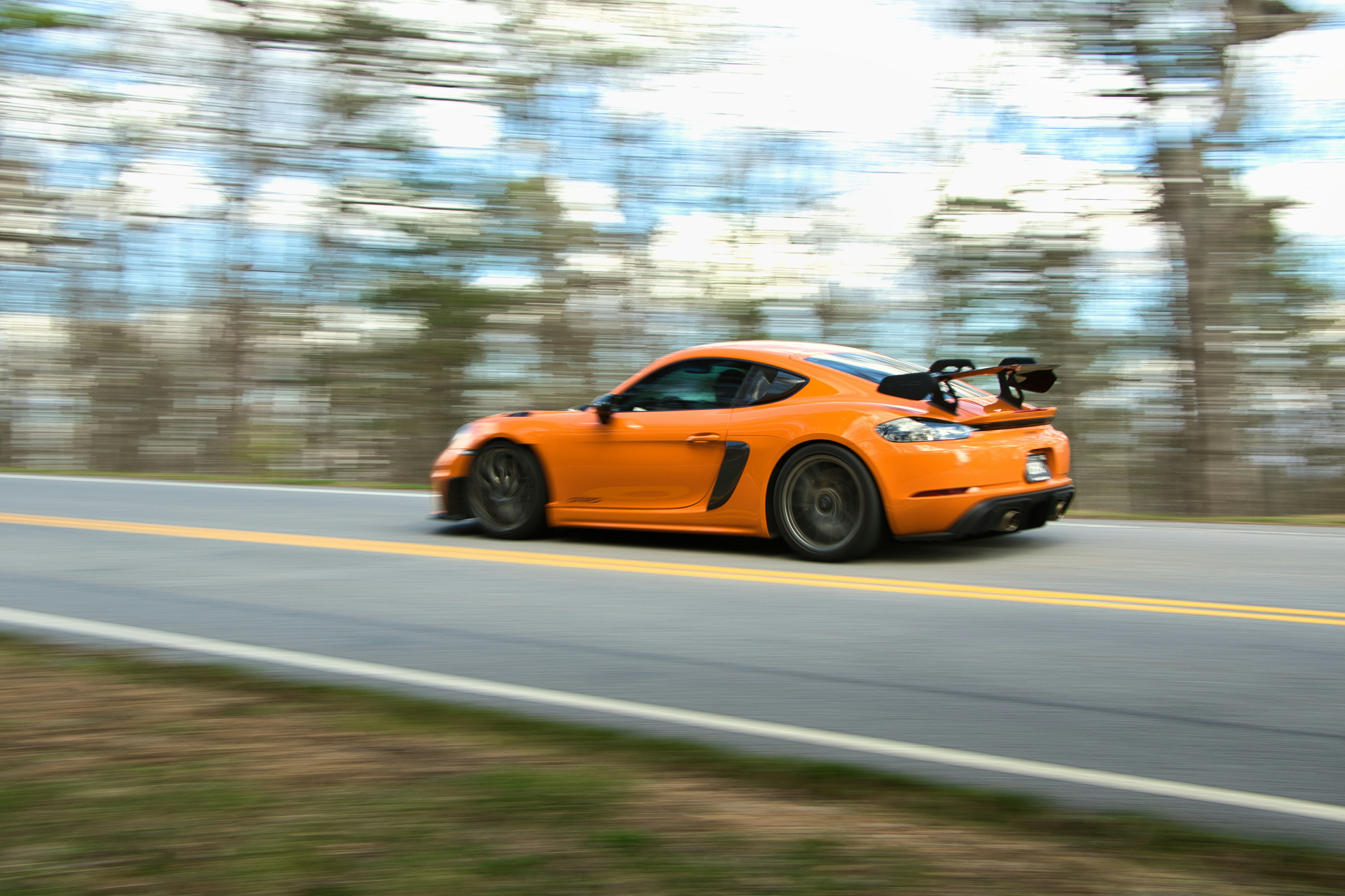Blazing Orange: A Car in Bold Motion Through a Blurred Landscape
