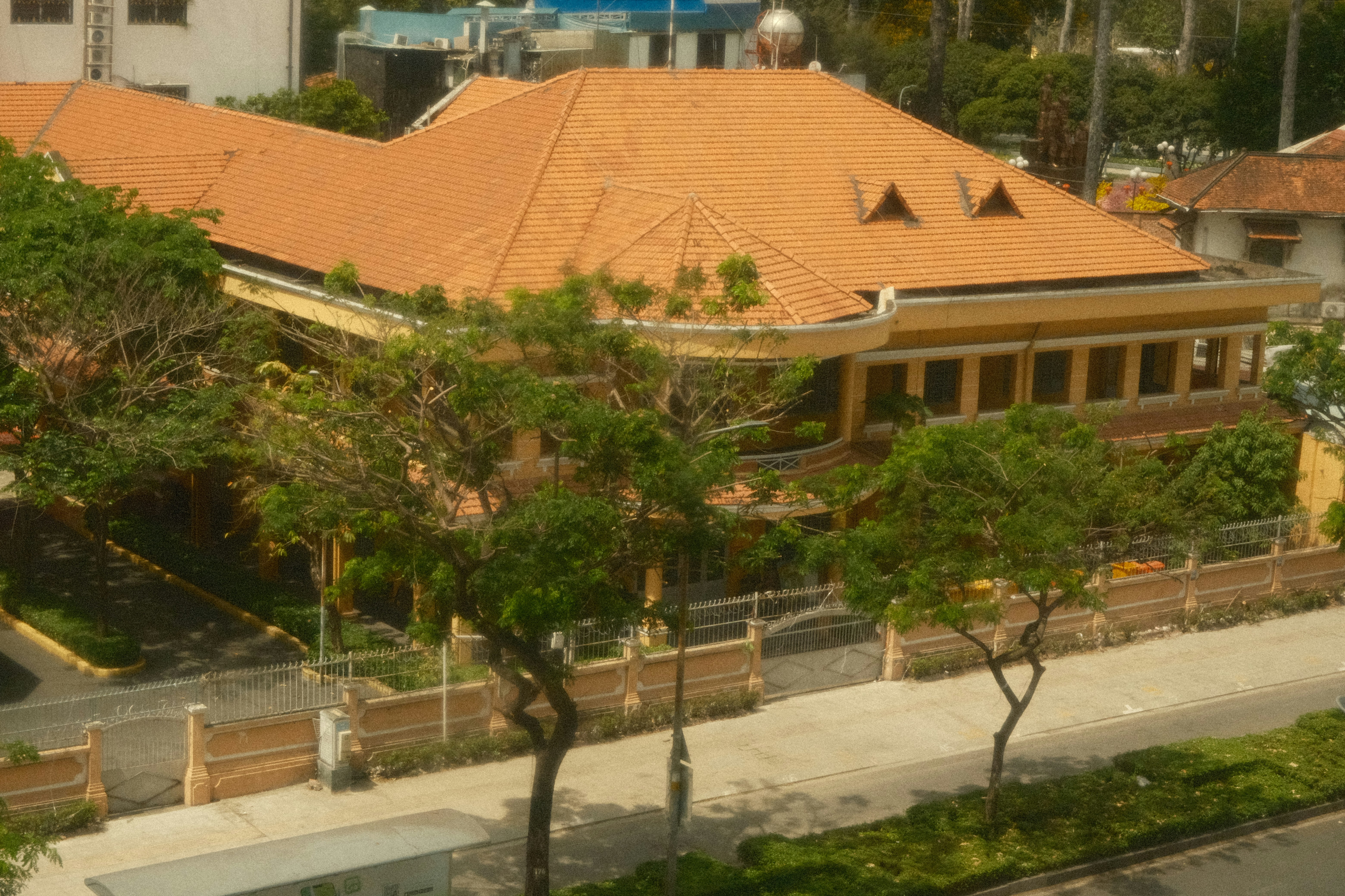 Terracotta Roofed Complex Framed by City Trees