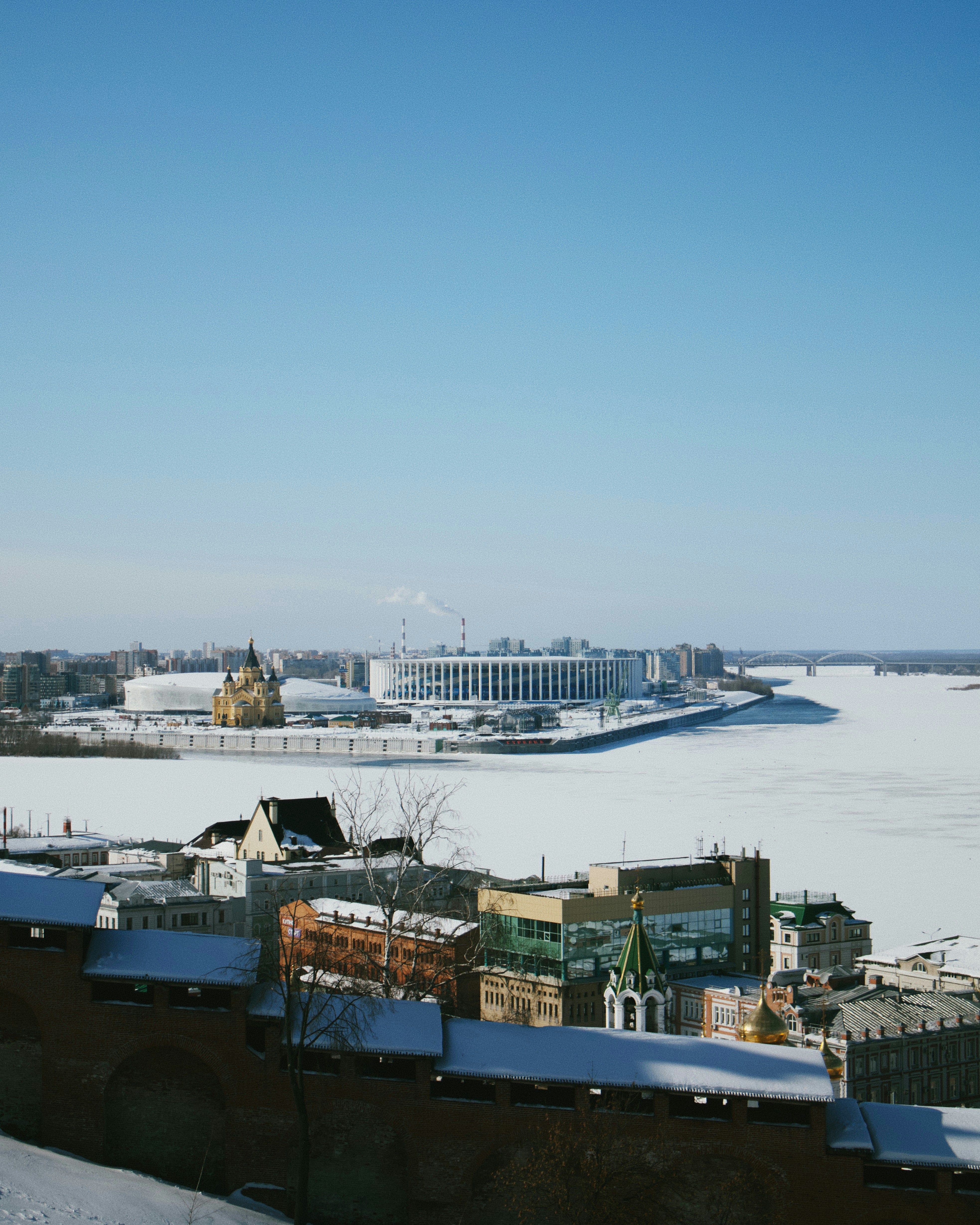 Winter Riverbend: Snow-Covered Cityscape with Golden Domes