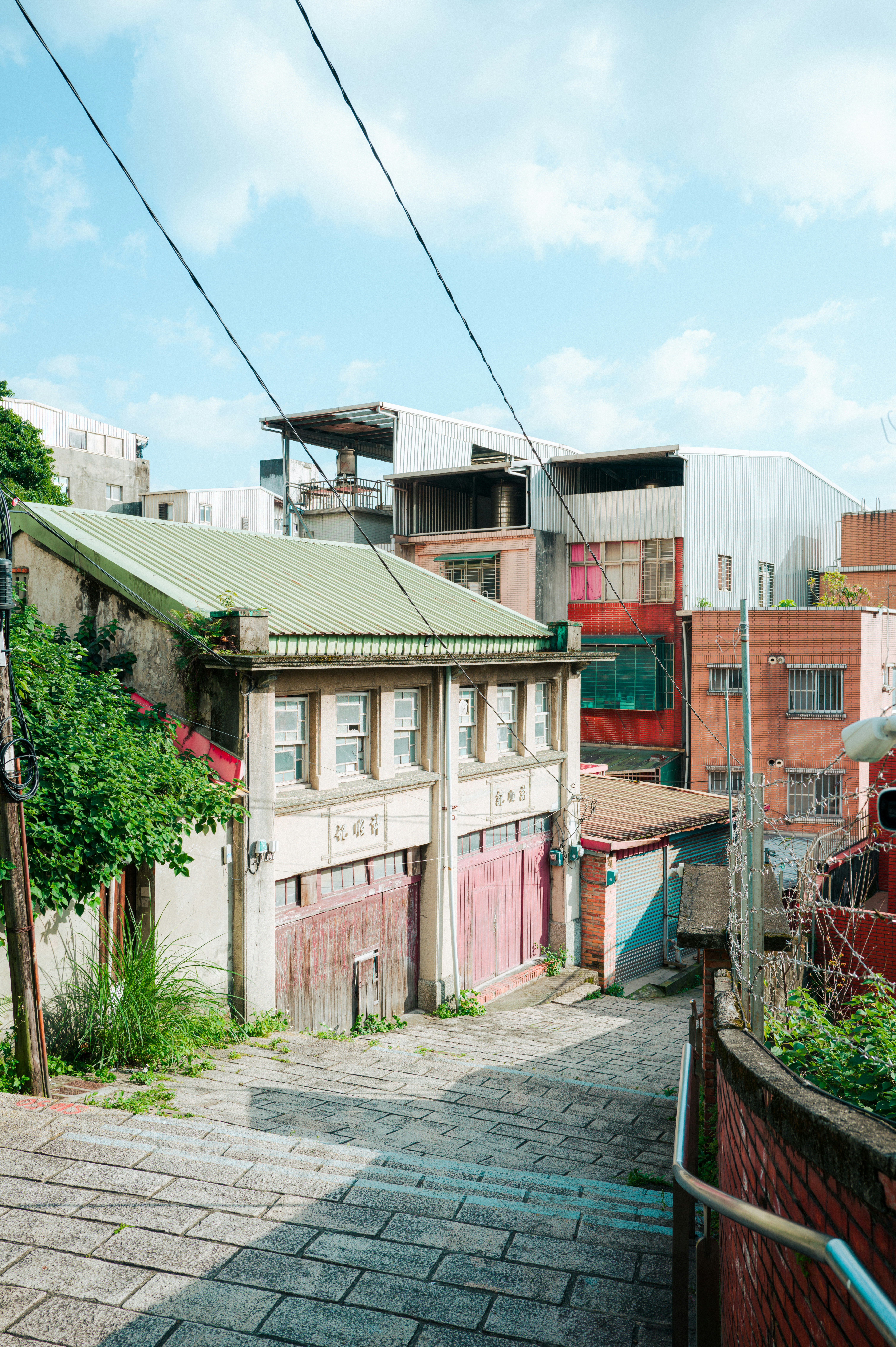 Sunlit Street of Colorful Apartments Descends from a Narrow Staircase
