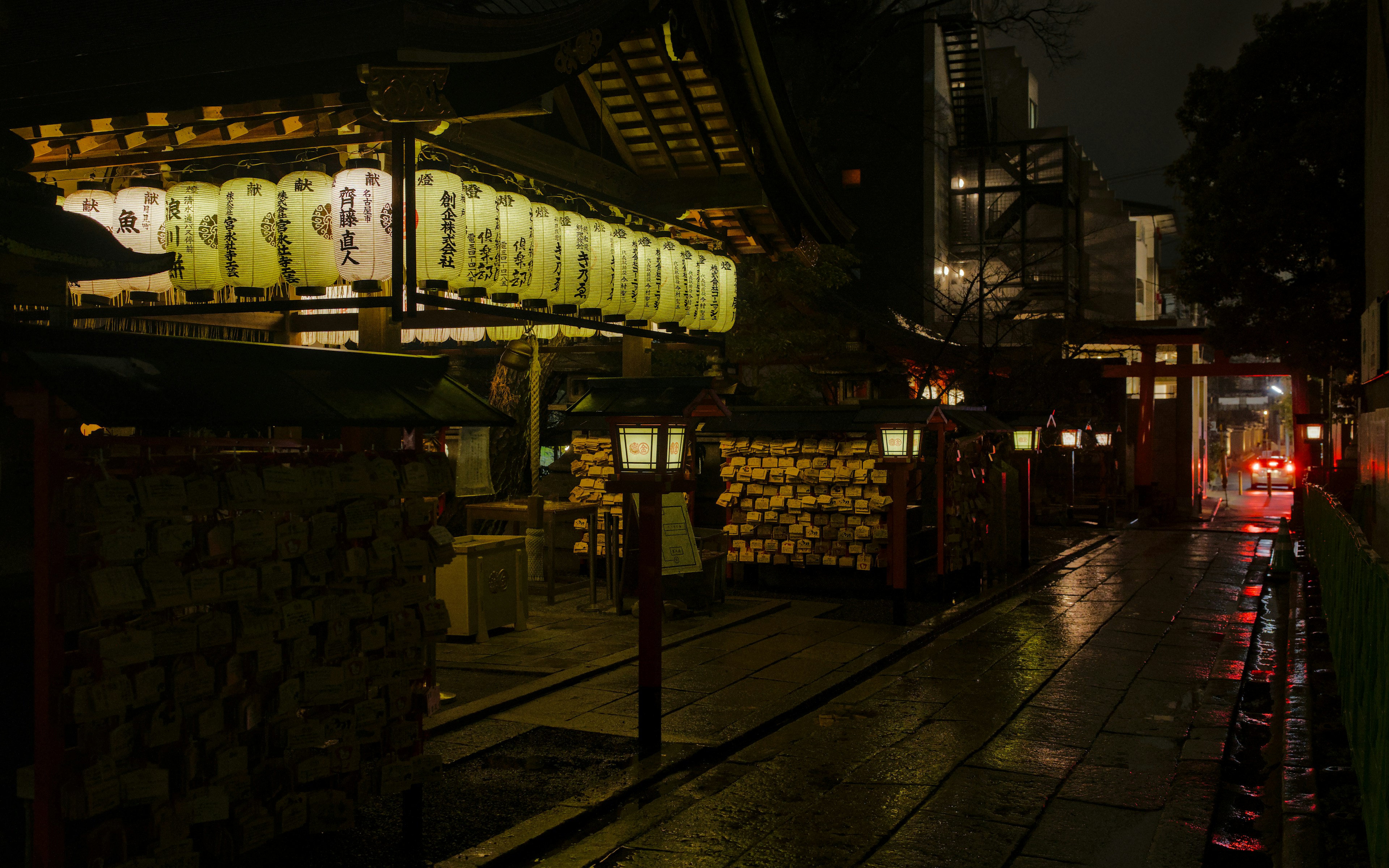 Lantern-lit Alleyway: Rain-slicked Path Under Ancient Rooflines