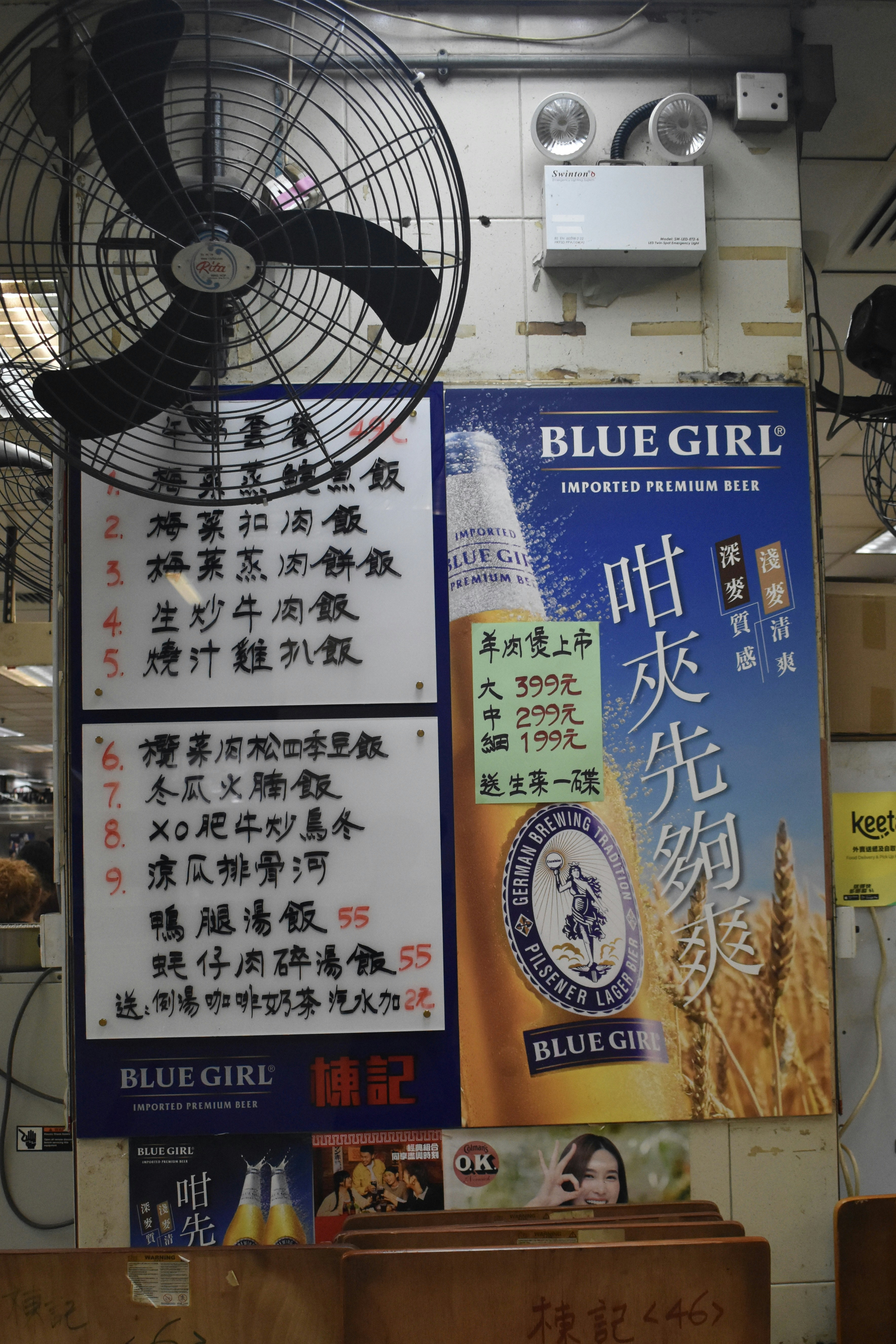 Blue Girl Menu Wall: A Neon-Blue Signboard Framed by Industrial Fans