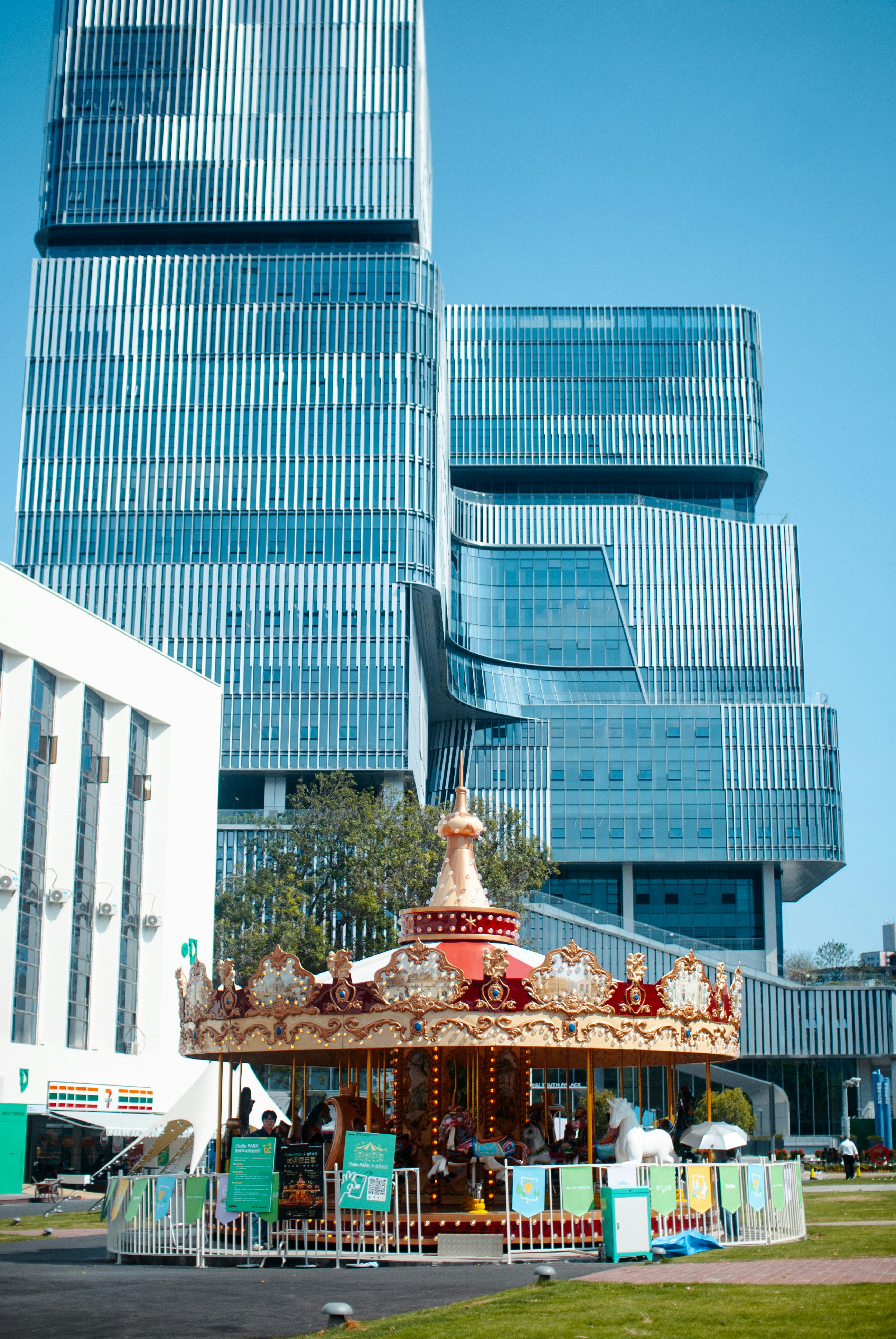Carousel Beneath Towering Glass: A playground of contrast