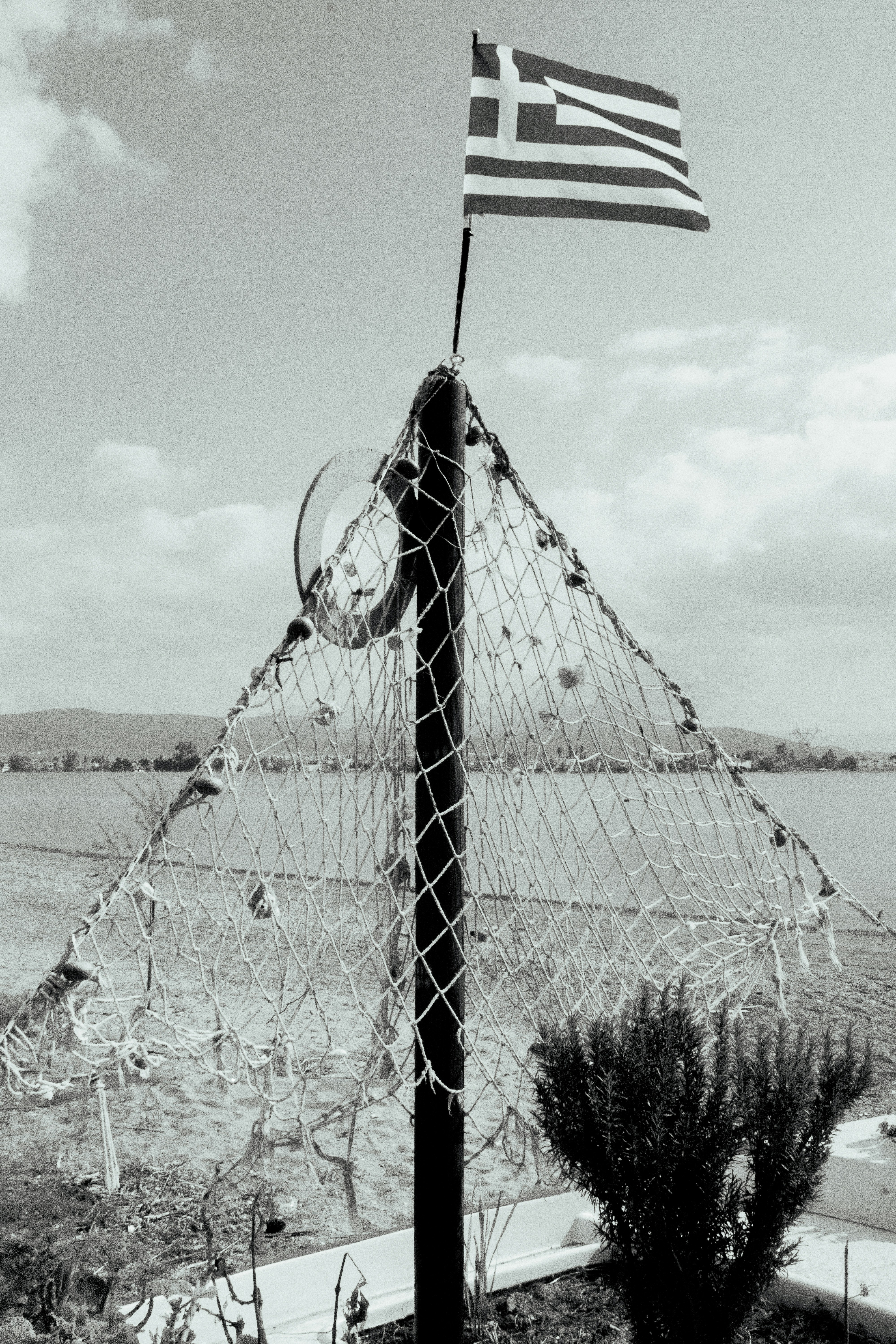 Flag over Nets and Shoreline: A Quiet Maritime Moment
