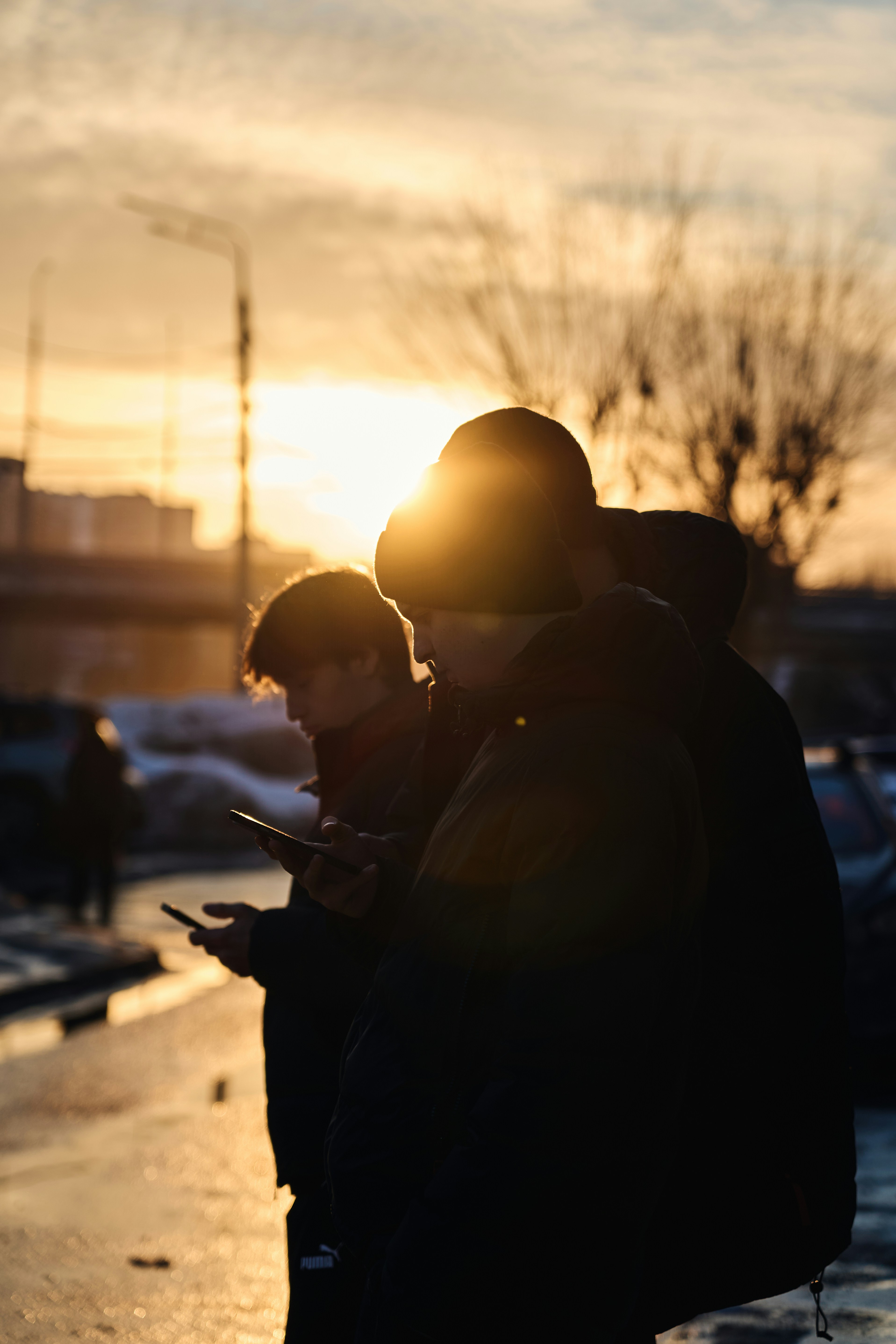 Backlit silhouettes: a quiet moment as the sun slips behind the hooded figures