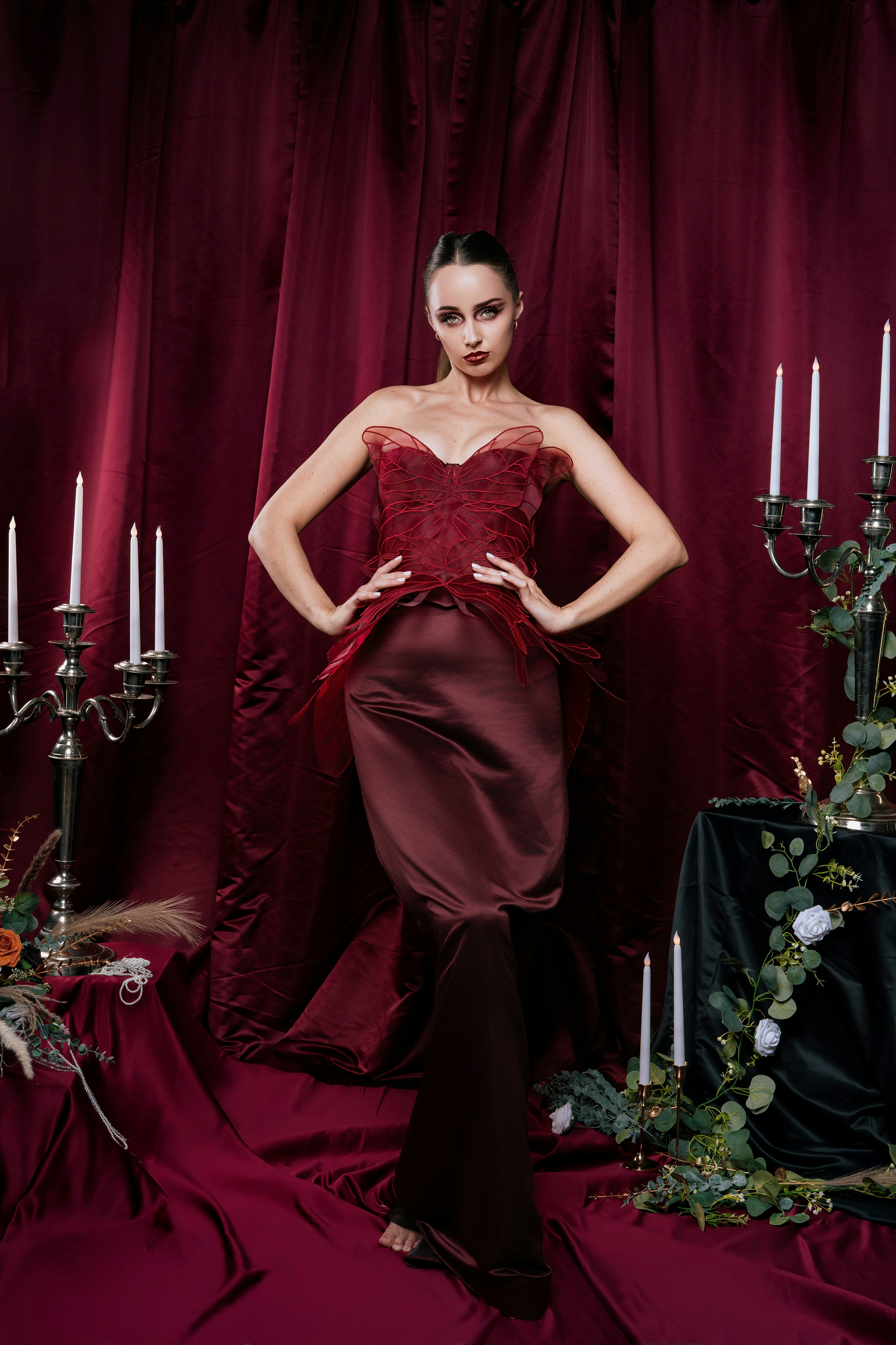 Velvet Reverie: A Regal Pose Amidst Satin and Silver Candlesticks