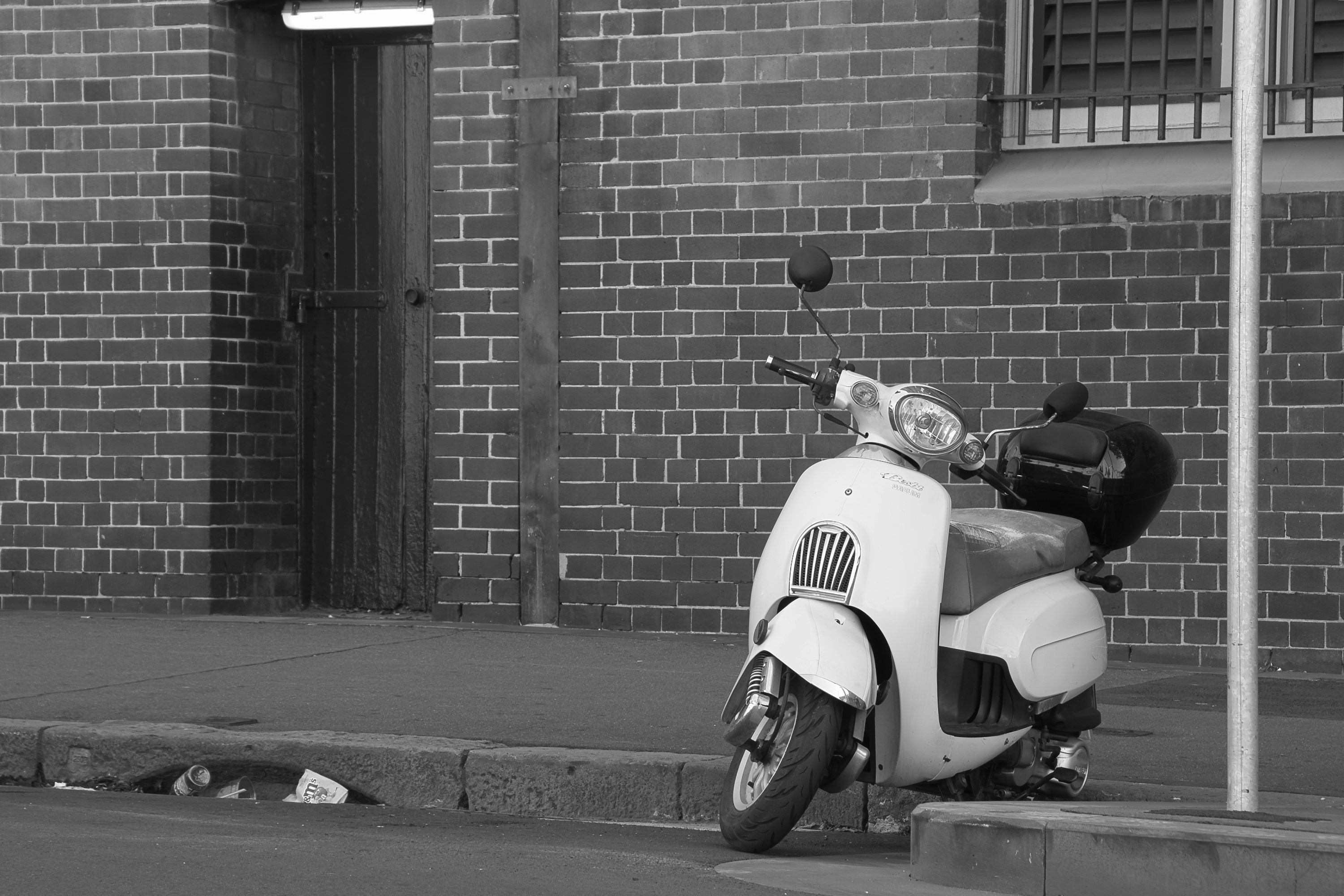 Quiet Street Sentinel: A vintage scooter at the curb under soft urban light