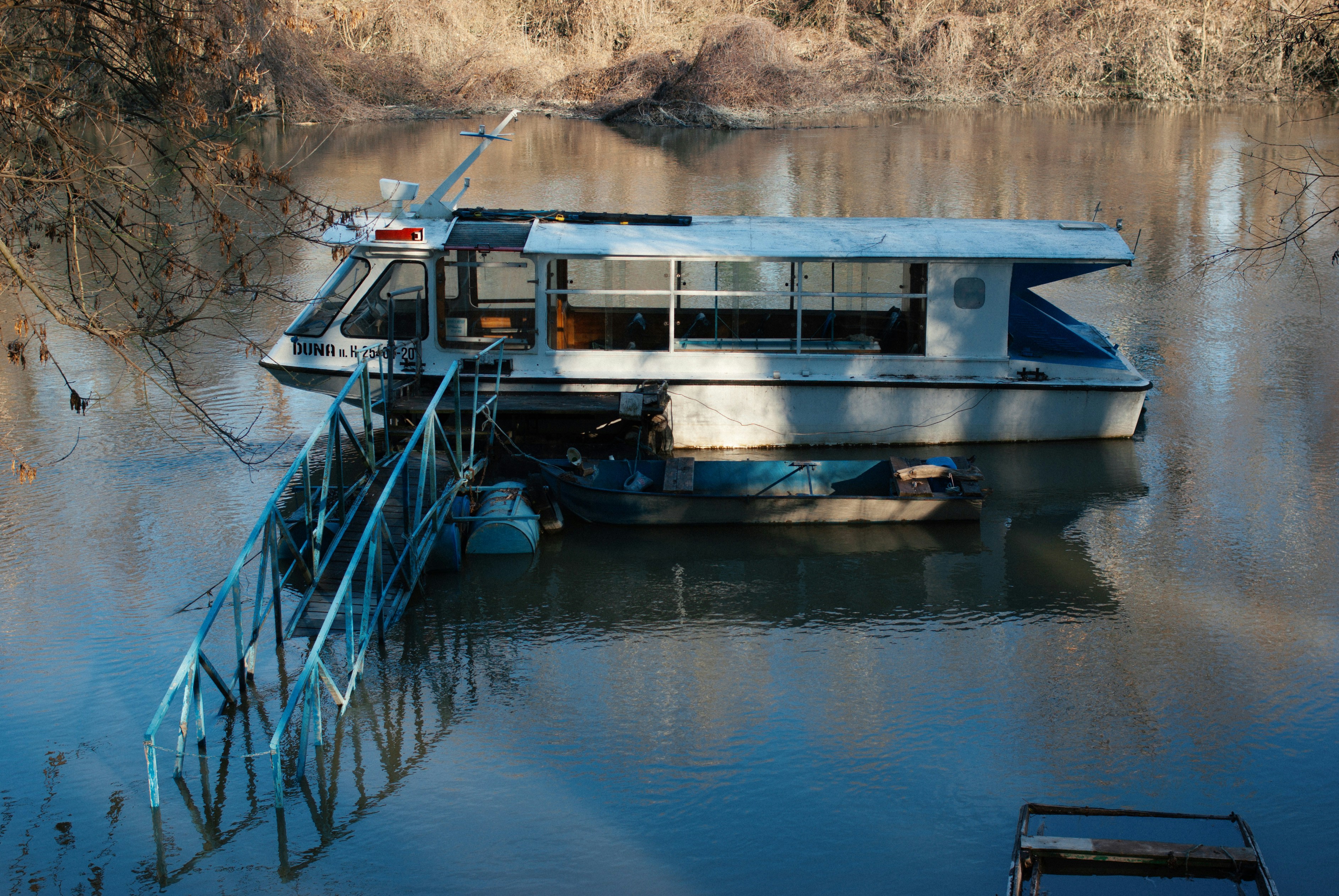 Blue River Vessel at Rest: A Quiet Slip into Glassy Waters