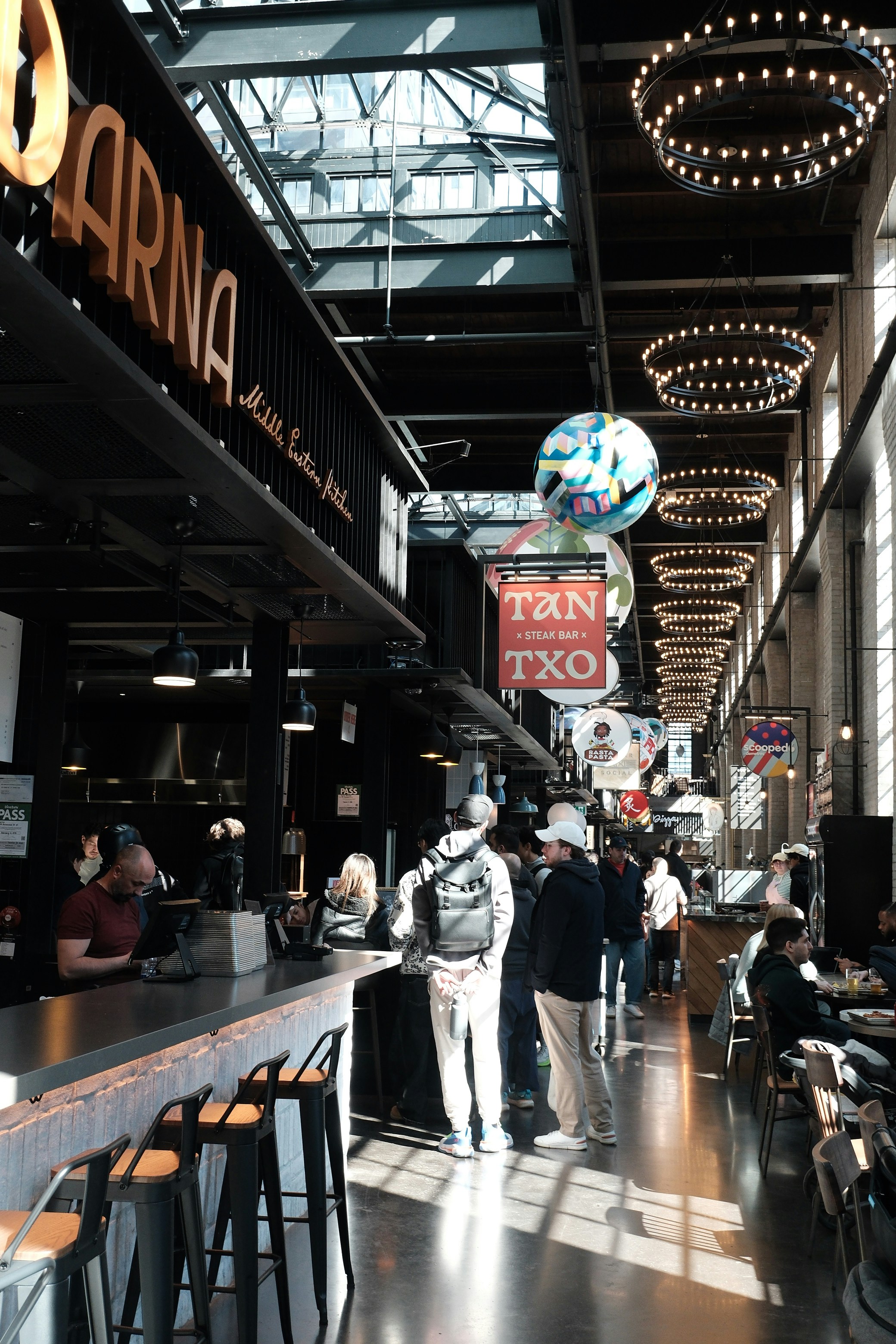 Market Valet: People, Light, and Neon Alleys Under Industrial Glass