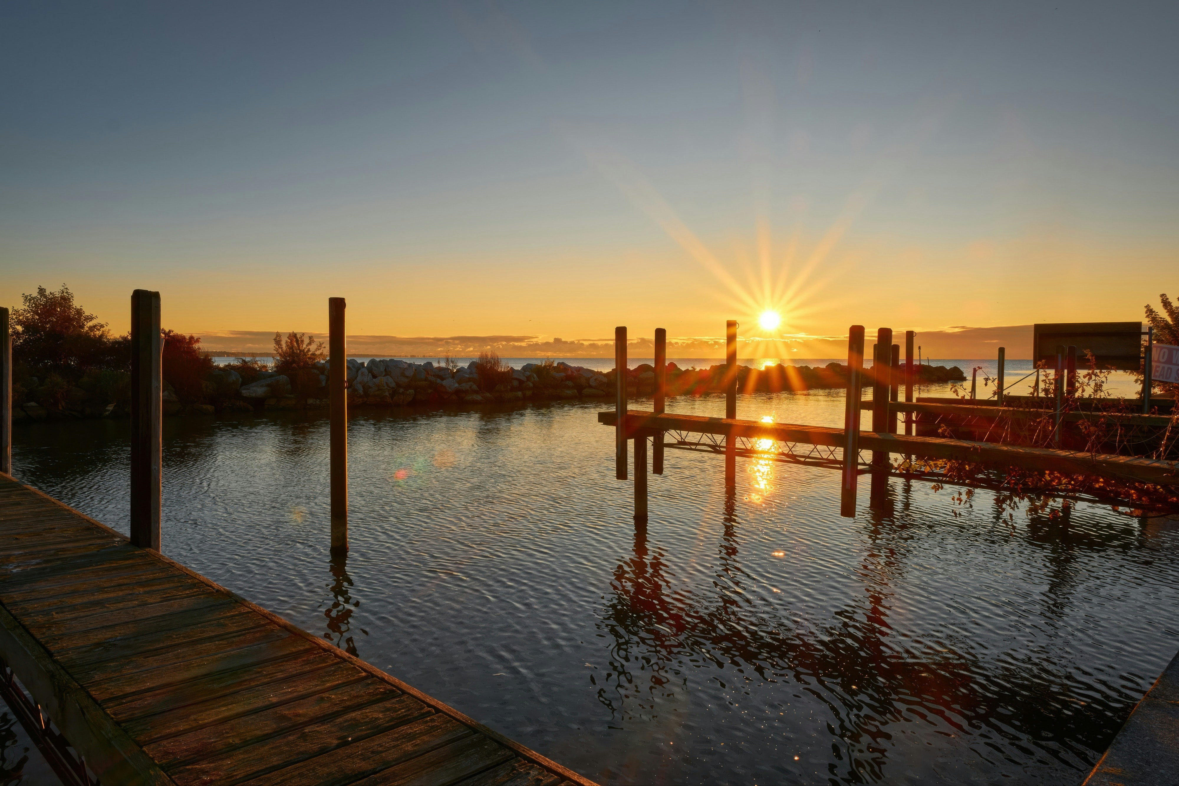 Silent Dusk at the Docks: Sunburst Over Calm Water